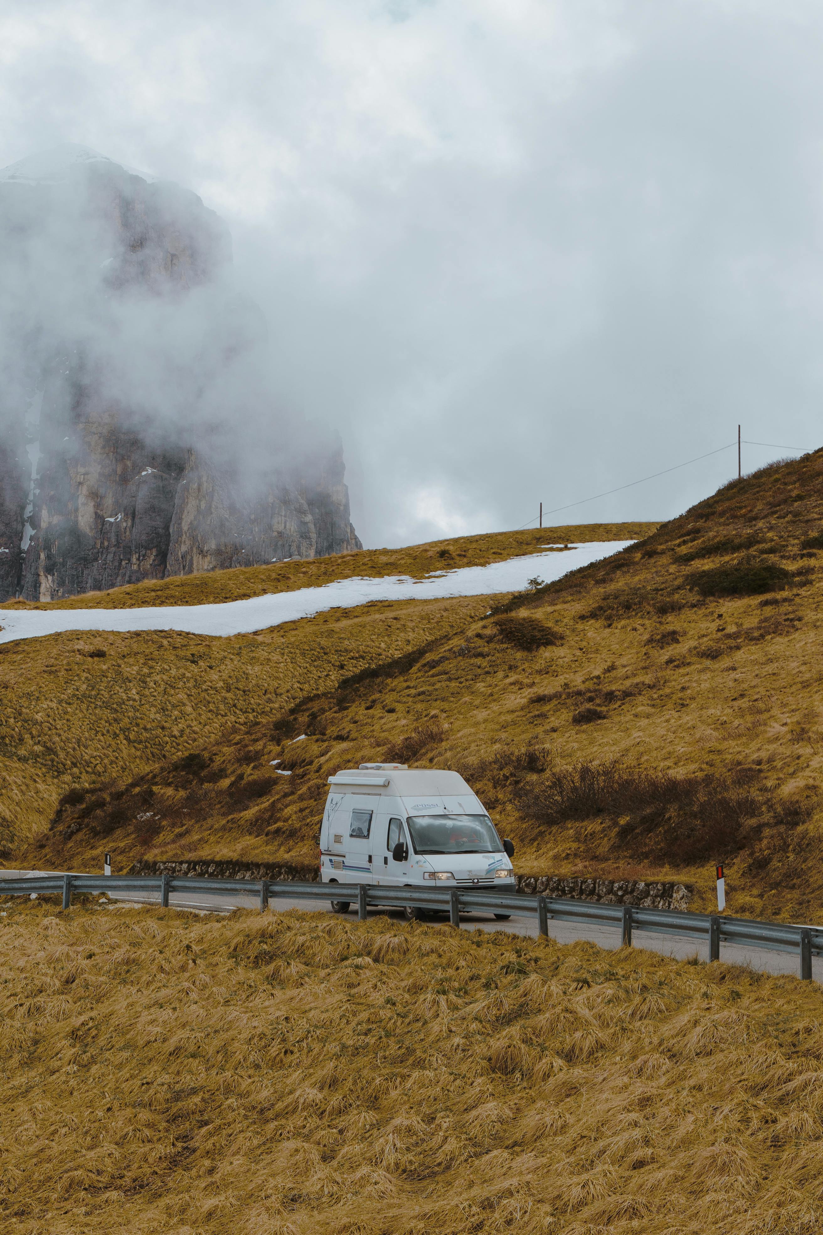 A van driving down a road with mountains in the background · Free Stock ...