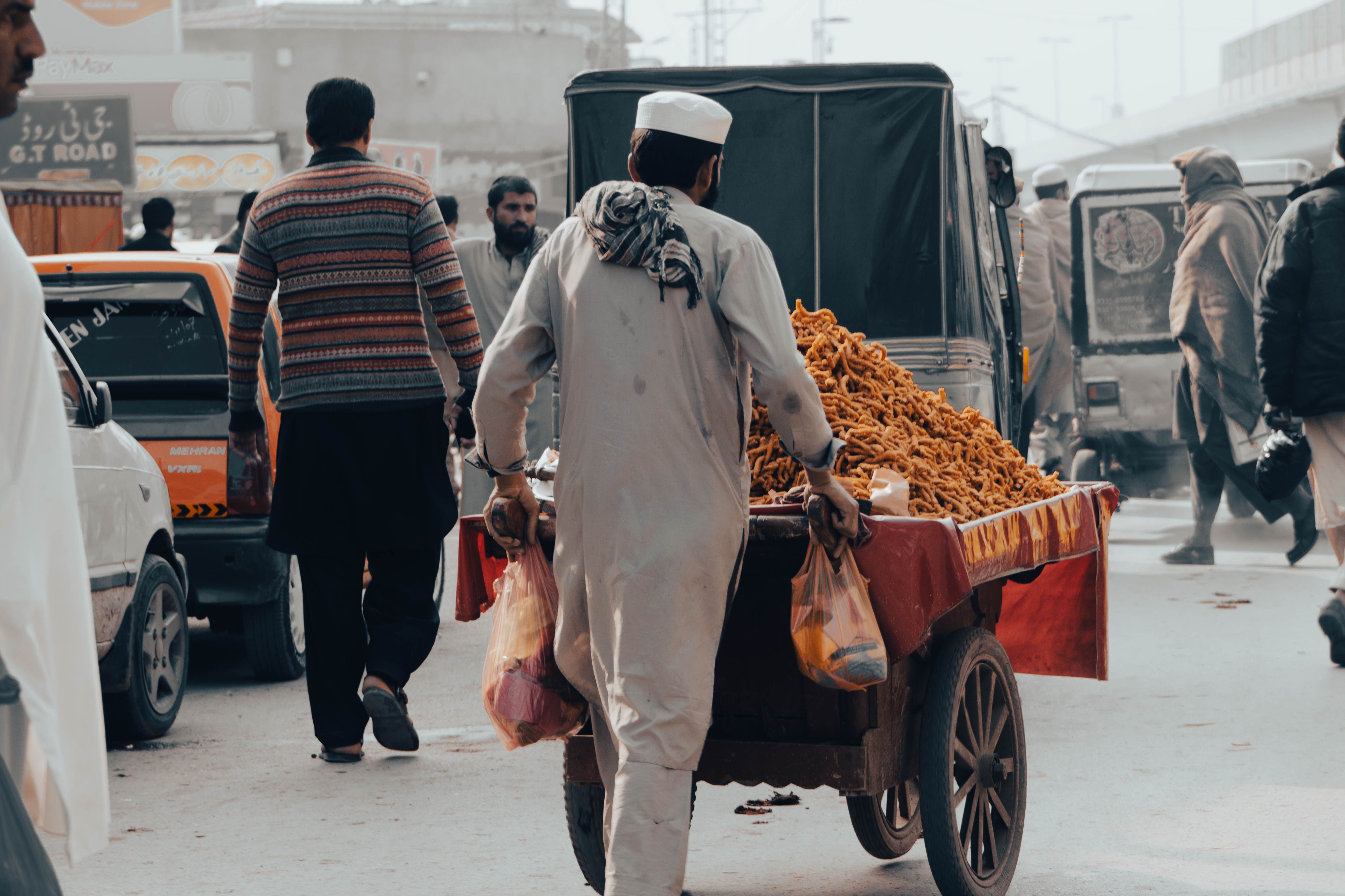 Men Pushing a Fully Loaded Cart on a City Street · Free Stock Photo
