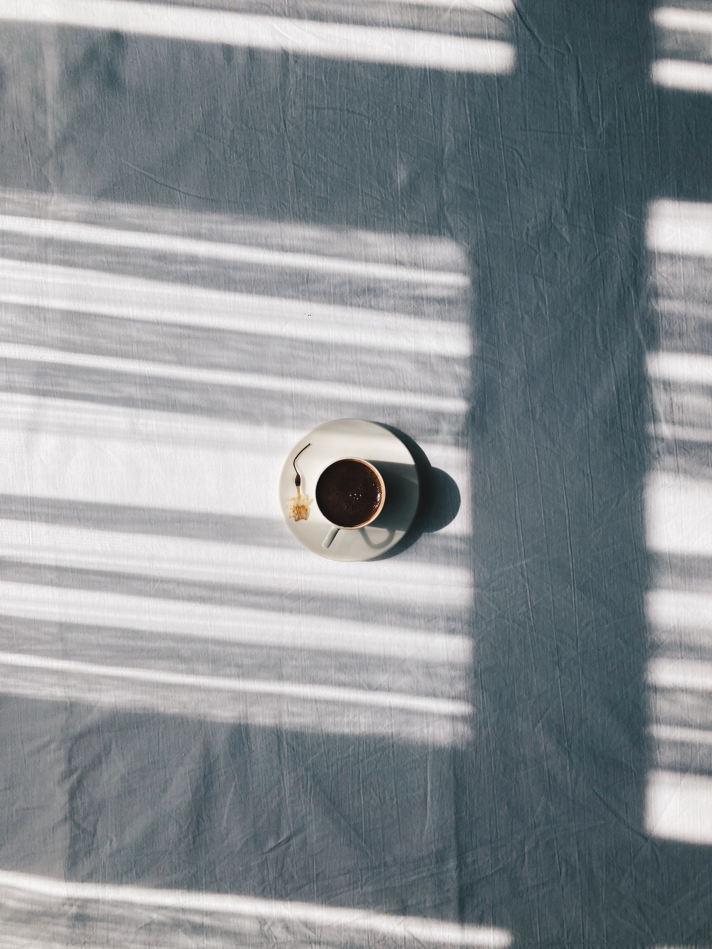 Top View of Coffee Cup on Shaded Fabric · Free Stock Photo
