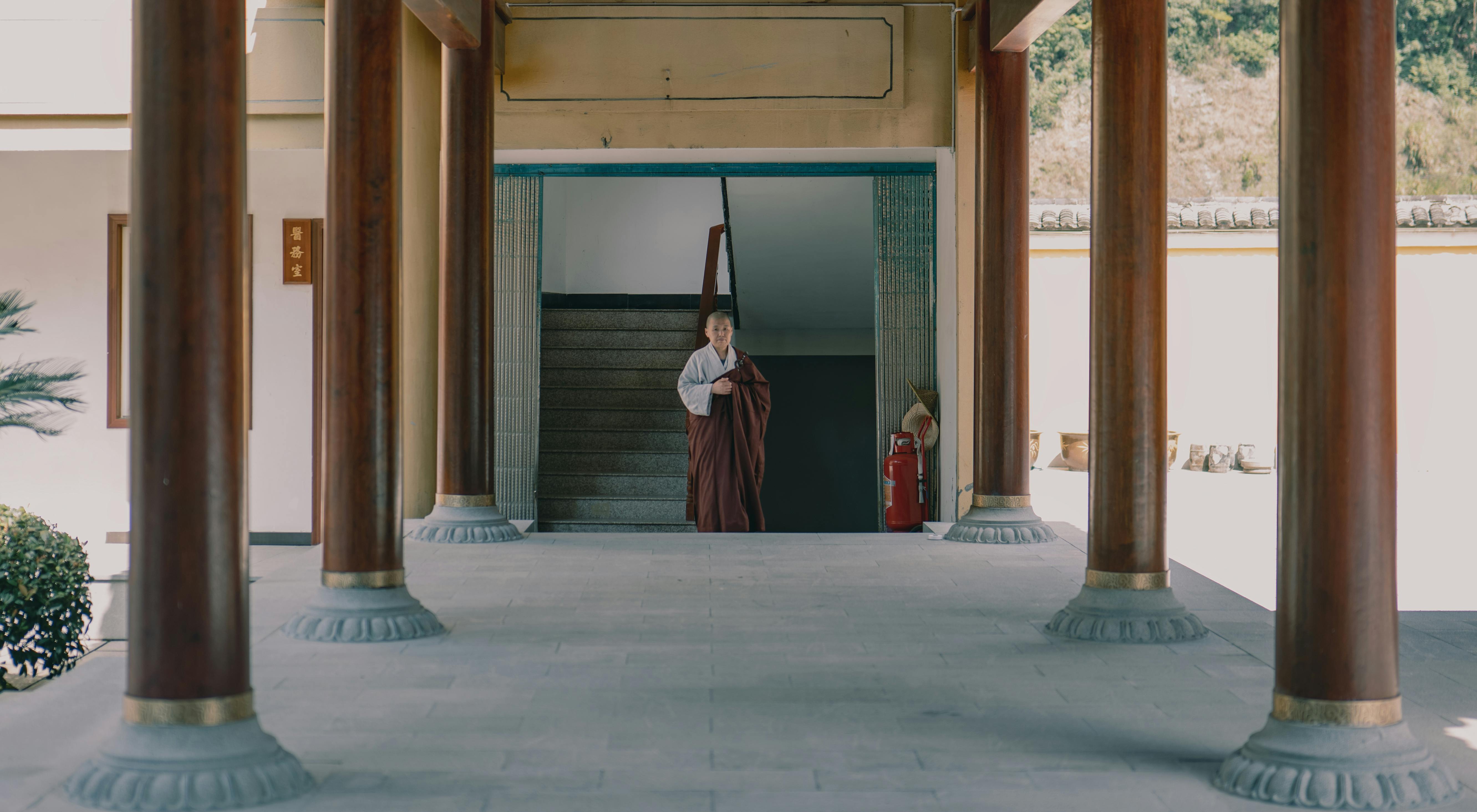 Buddhist Monk Standing in Temple Entrance · Free Stock Photo