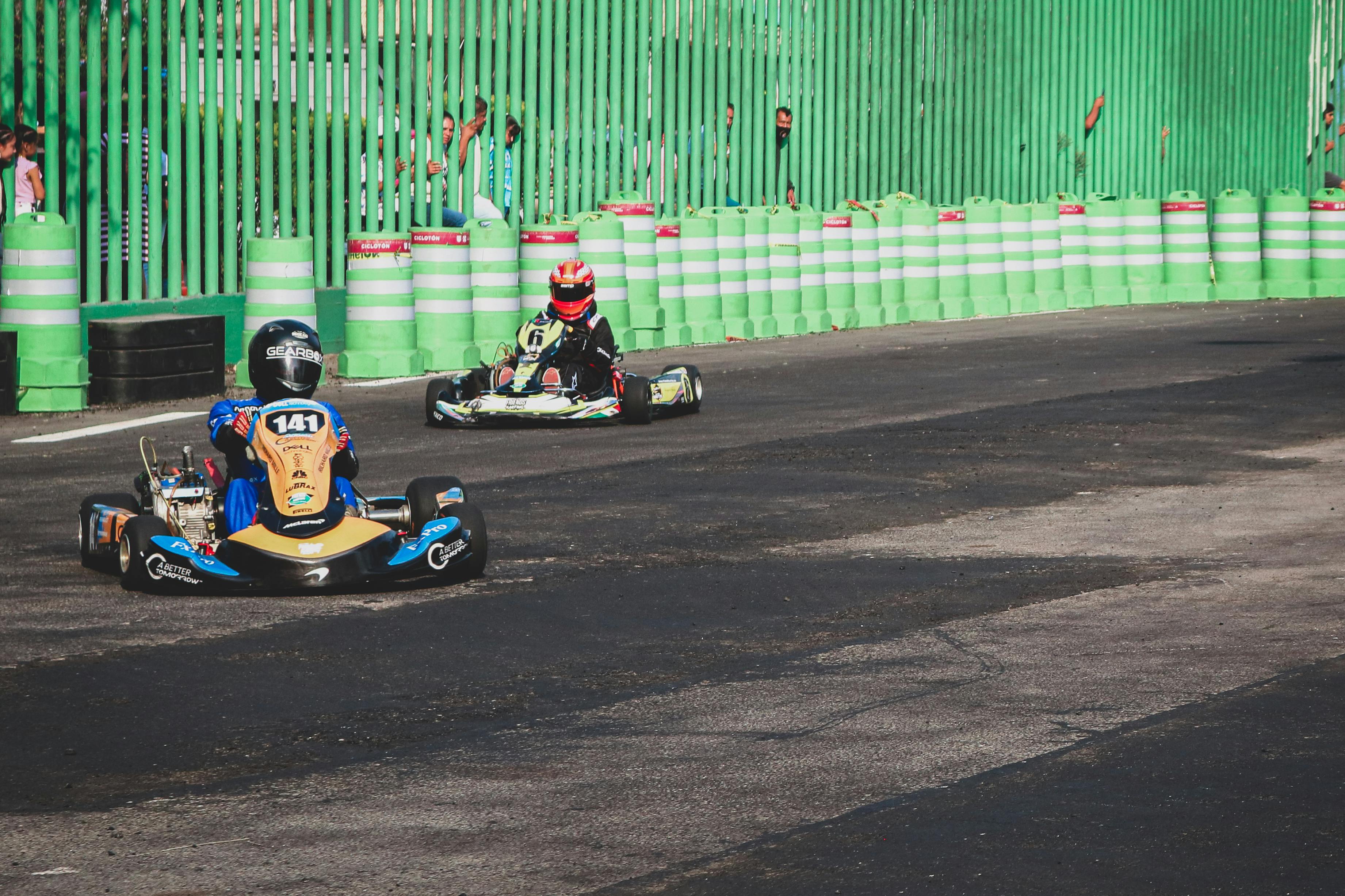 Two go kart drivers racing on a track · Free Stock Photo