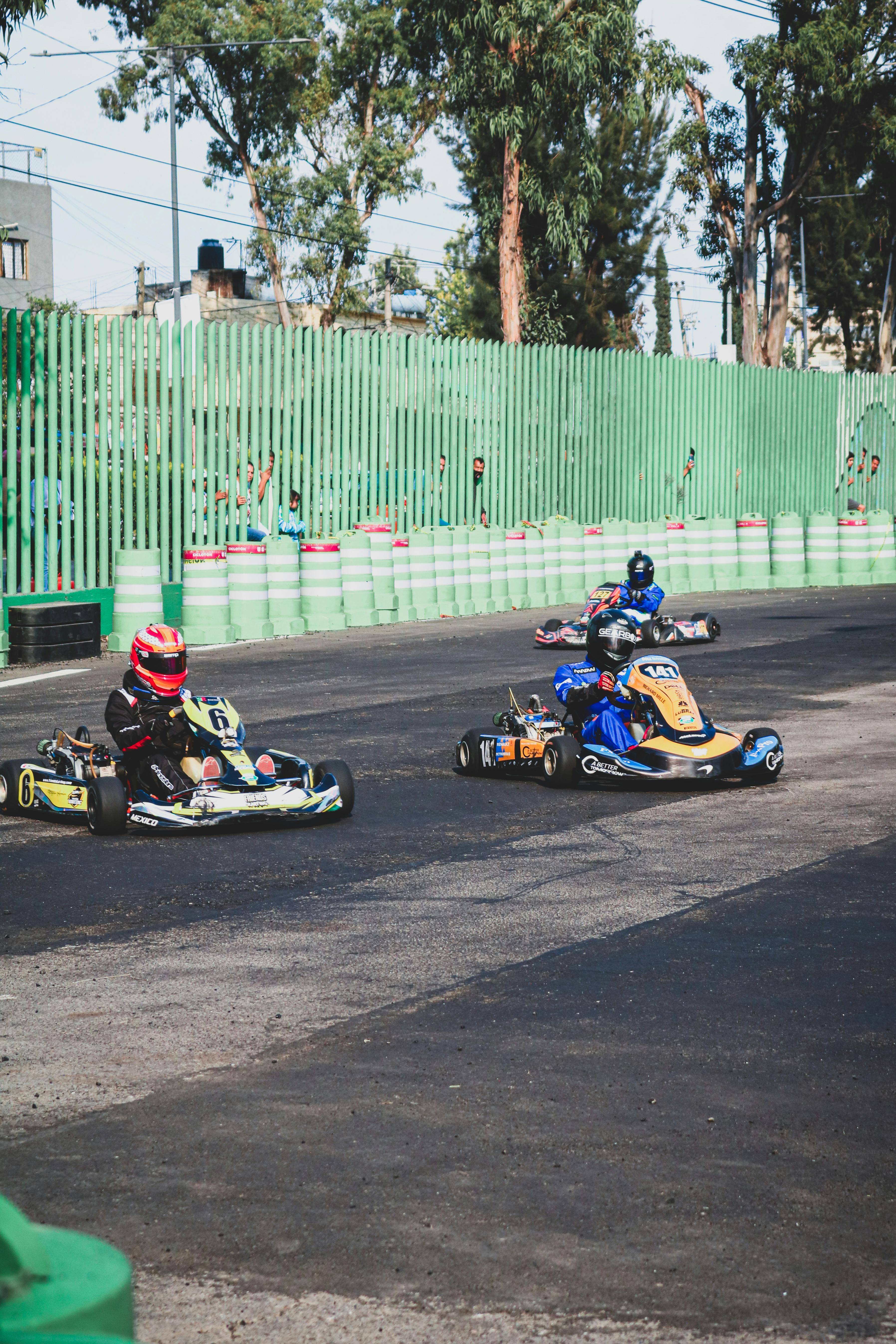 Two people riding go karts on a track · Free Stock Photo