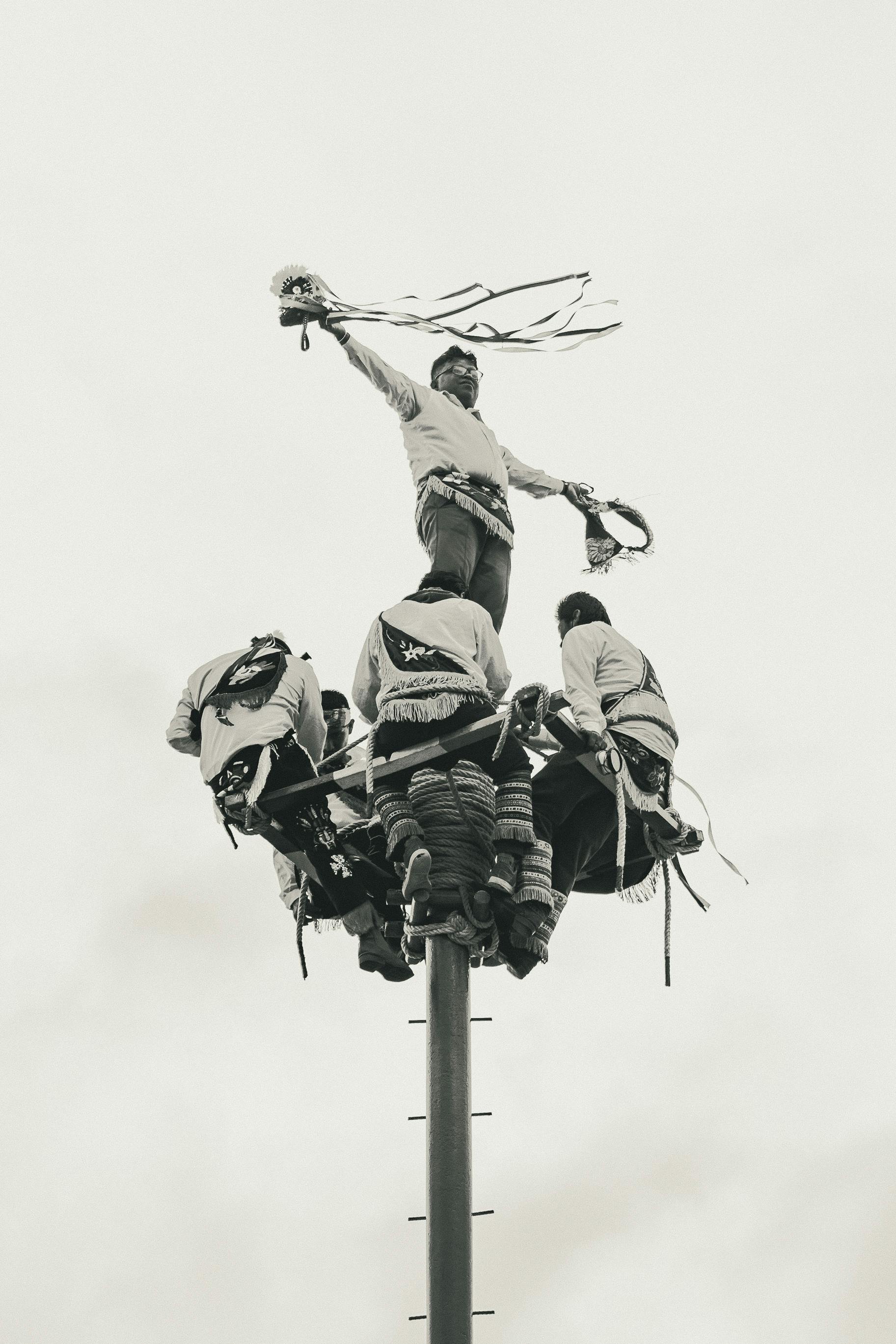 Men on Pole in Festival in Black and White · Free Stock Photo