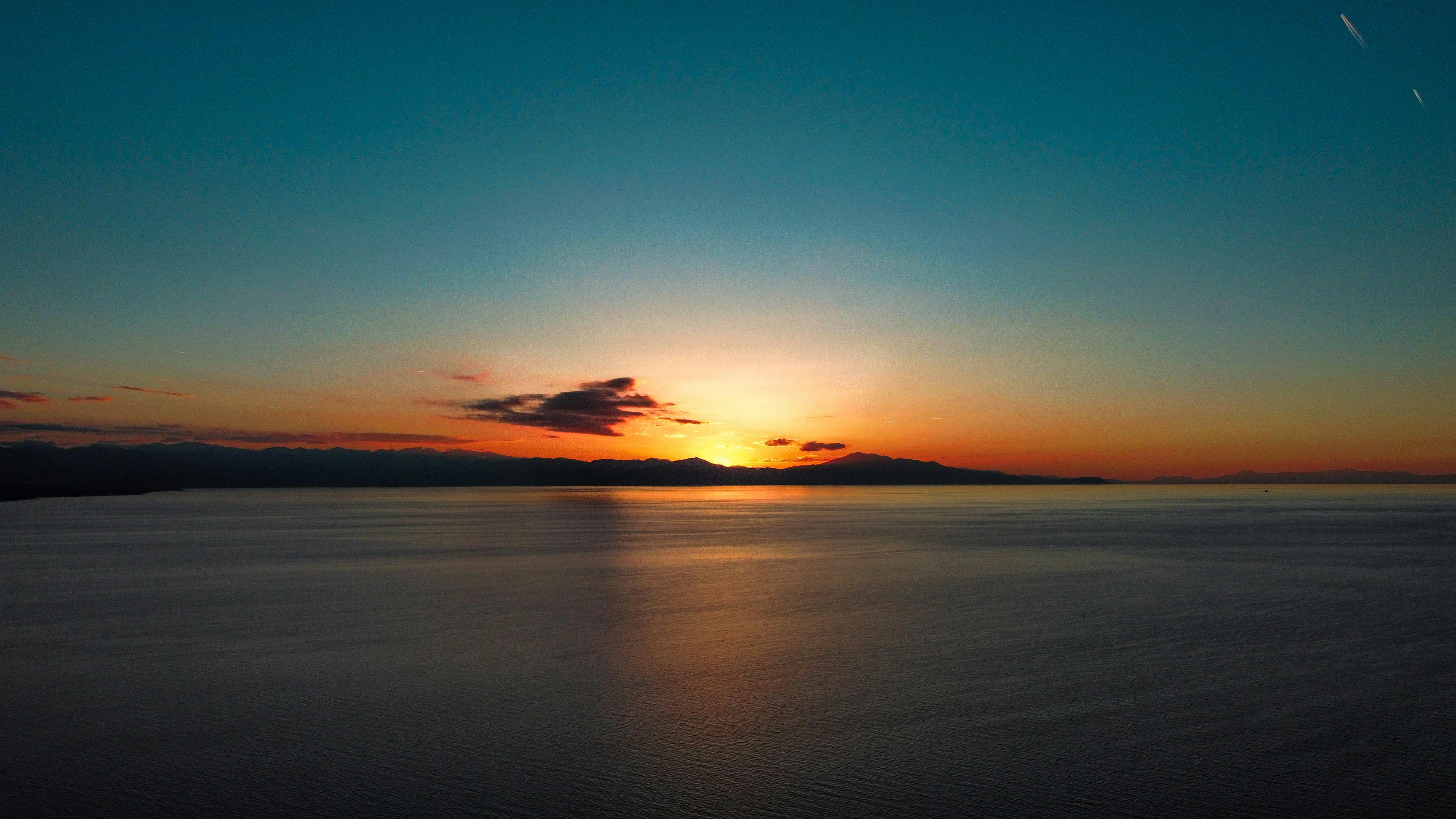 Sunset over Open Water under Clear Sky · Free Stock Photo