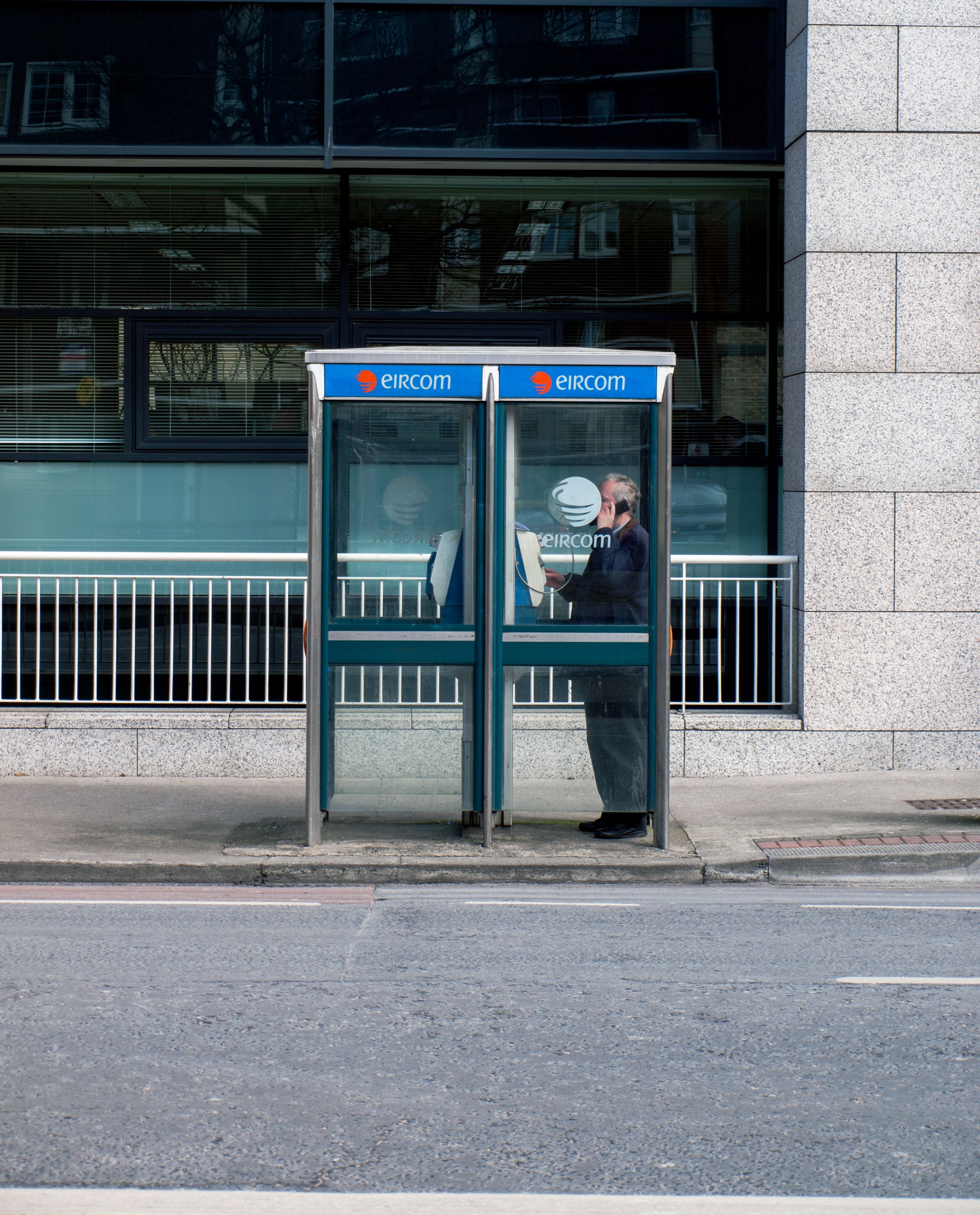 Urban Scene: Man in Dublin Phone Booth · Free Stock Photo