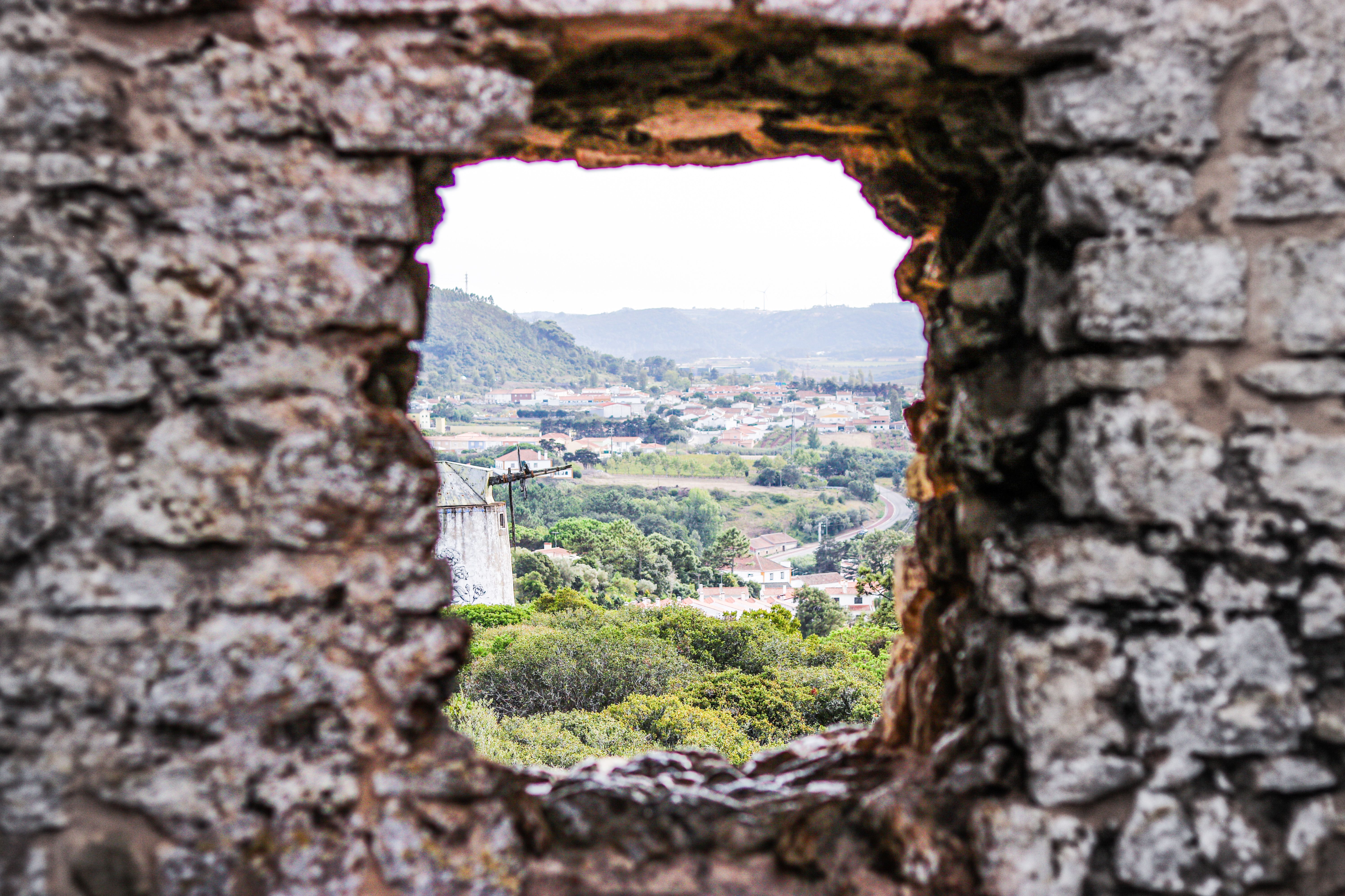 Town behind Hole in Stone Wall · Free Stock Photo
