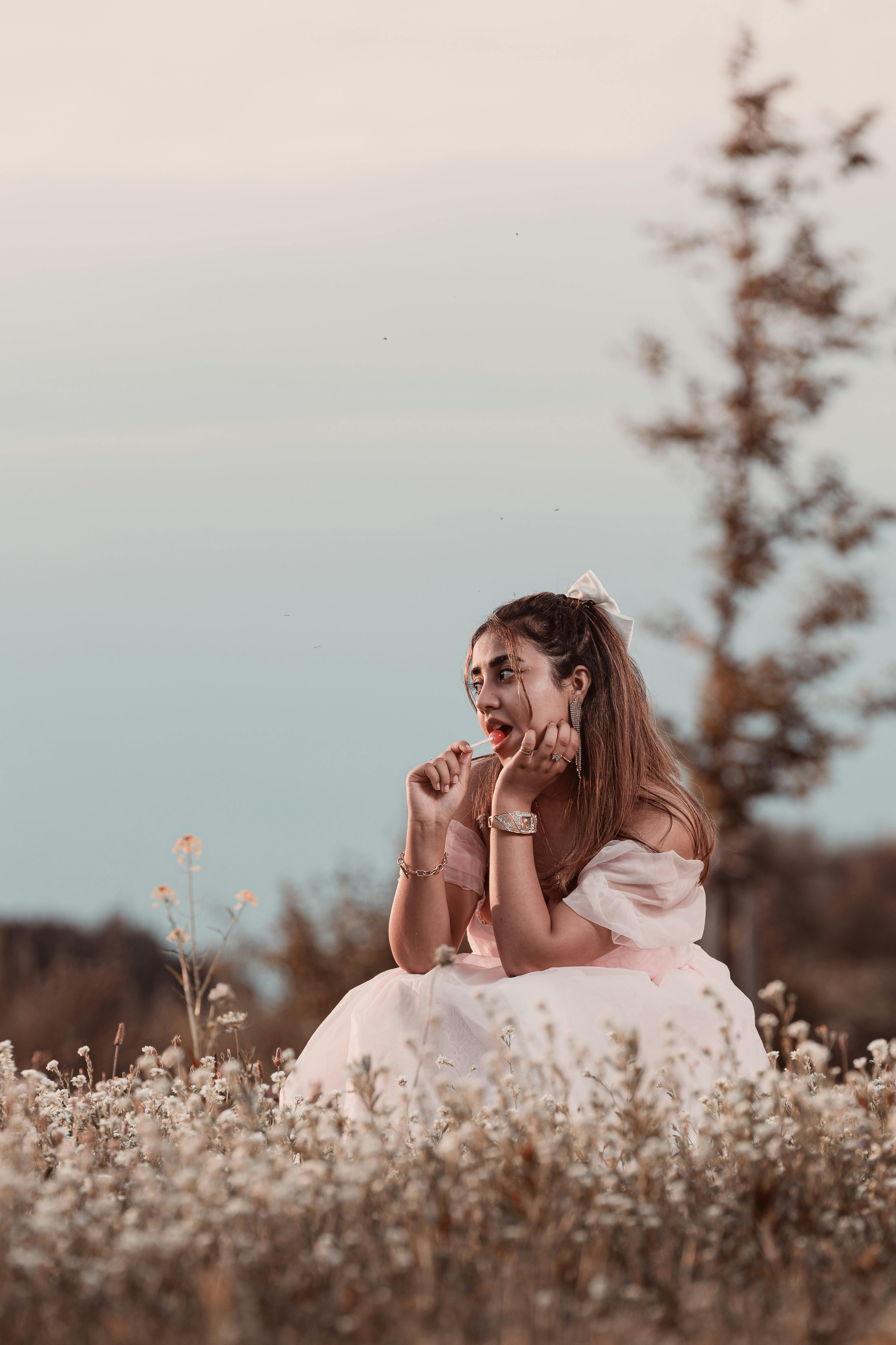 Blonde Woman in White Dress Squatting among Flowers on Meadow · Free ...