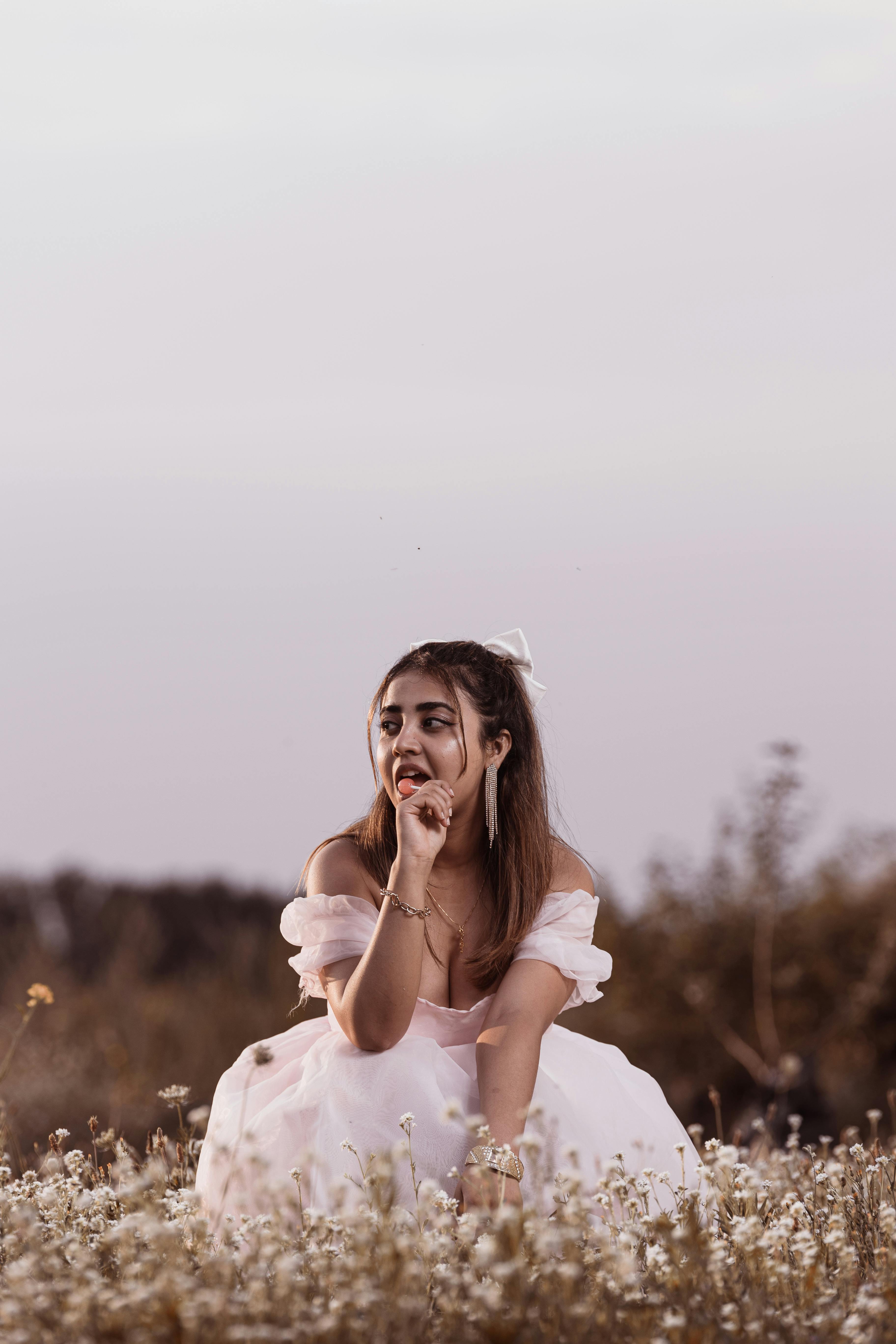 Blonde Woman in White Dress Squatting among Flowers on Meadow · Free ...