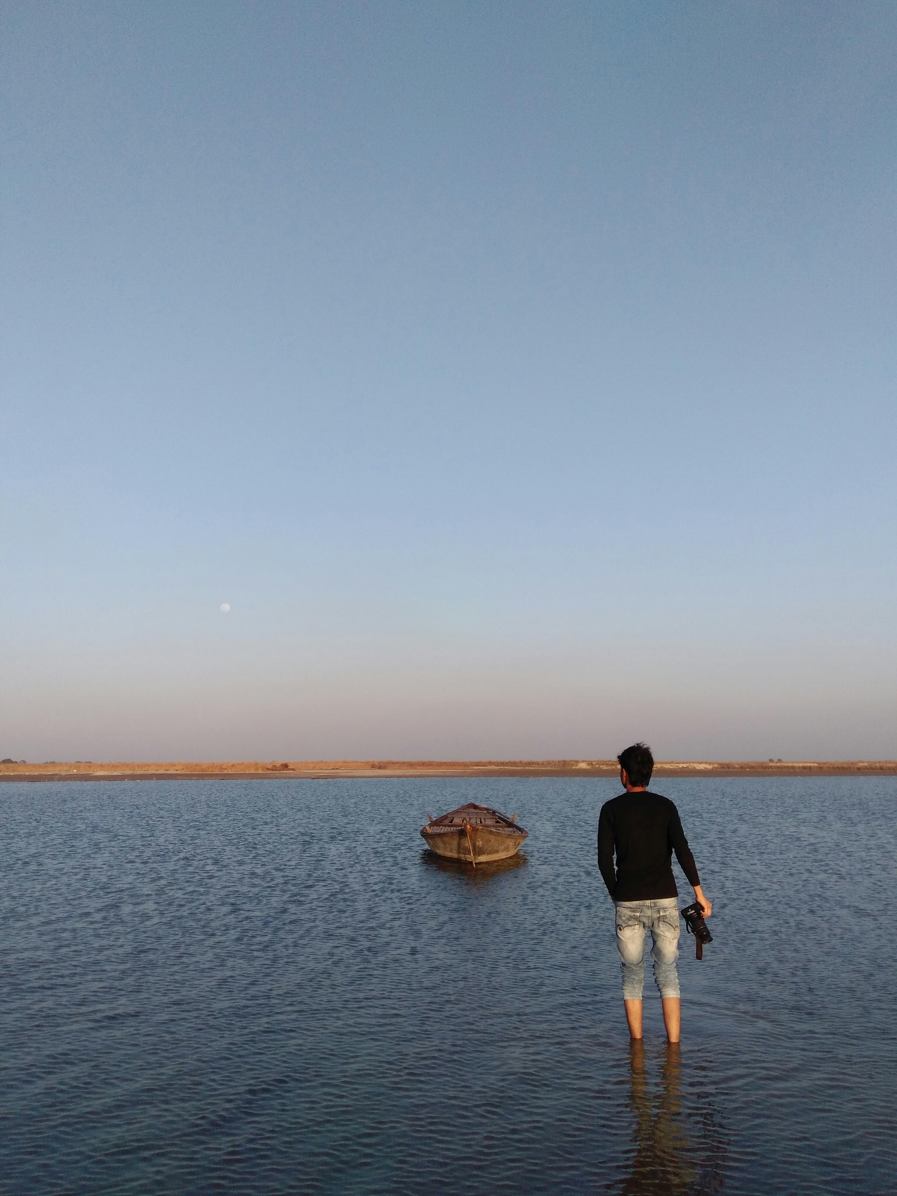 Person Wading in Shallow Tide Looking Out To Sea · Free Stock Photo