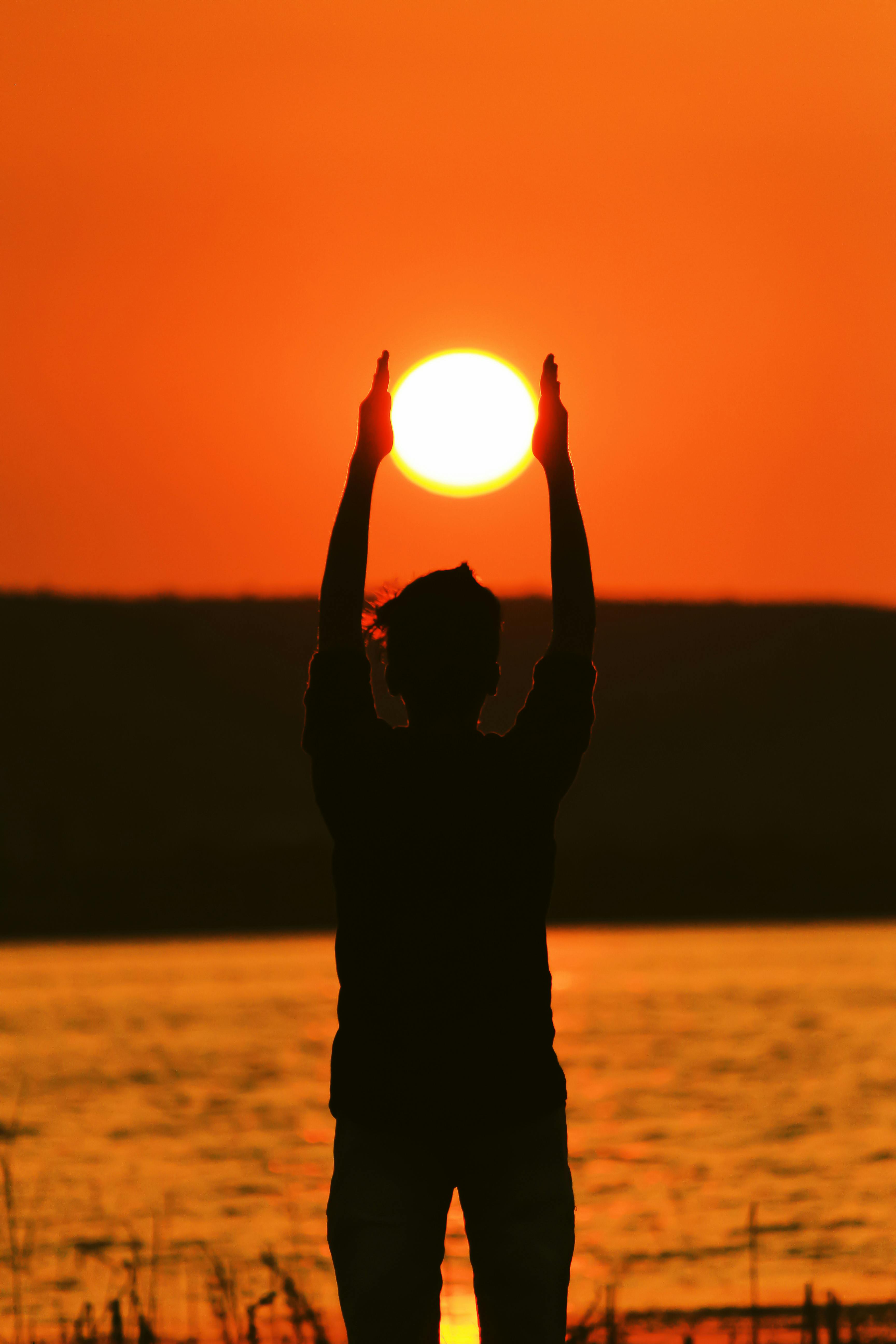 Person with Sun Between Hands · Free Stock Photo