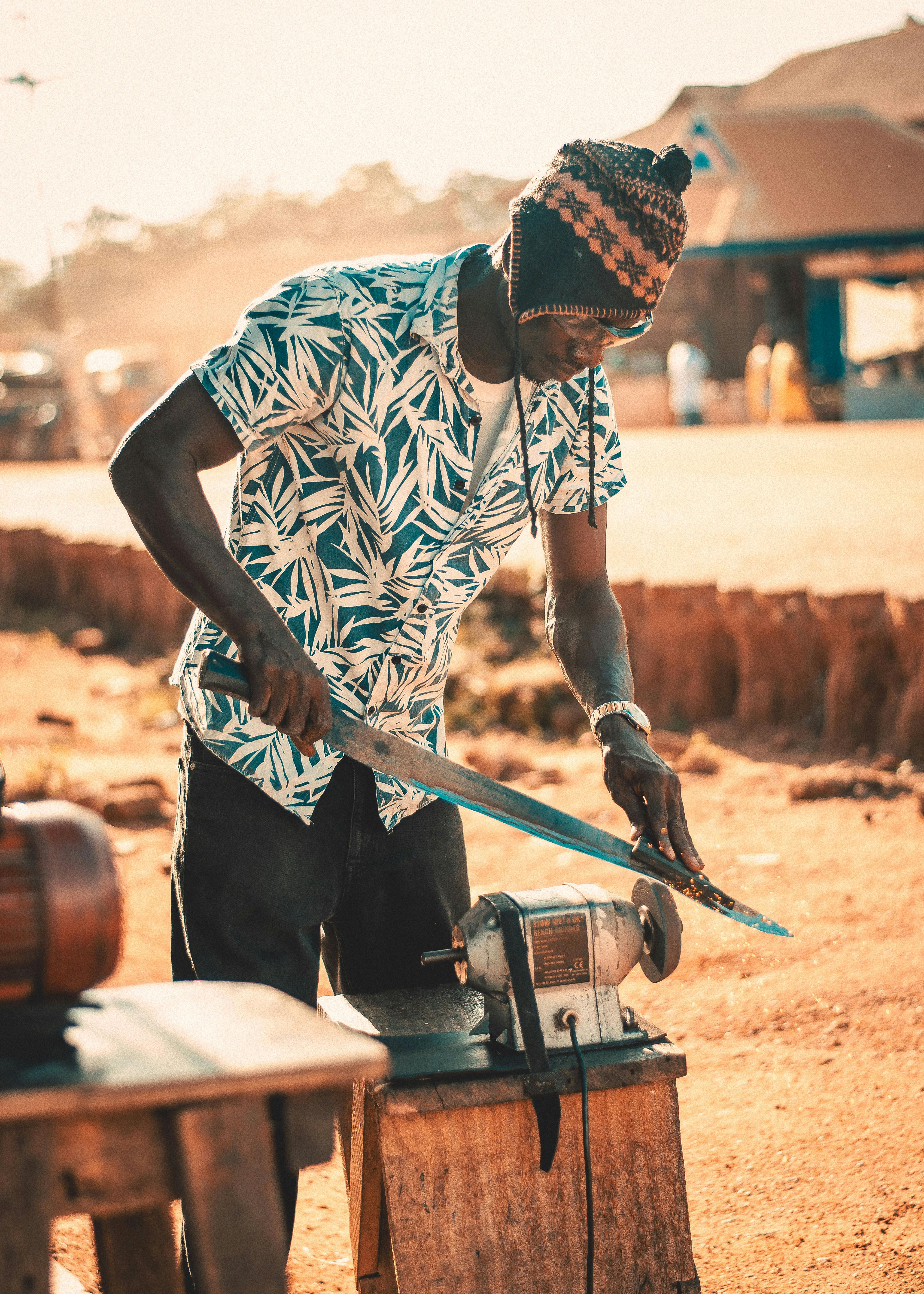 Man Using a Grinder to Make a Tool · Free Stock Photo