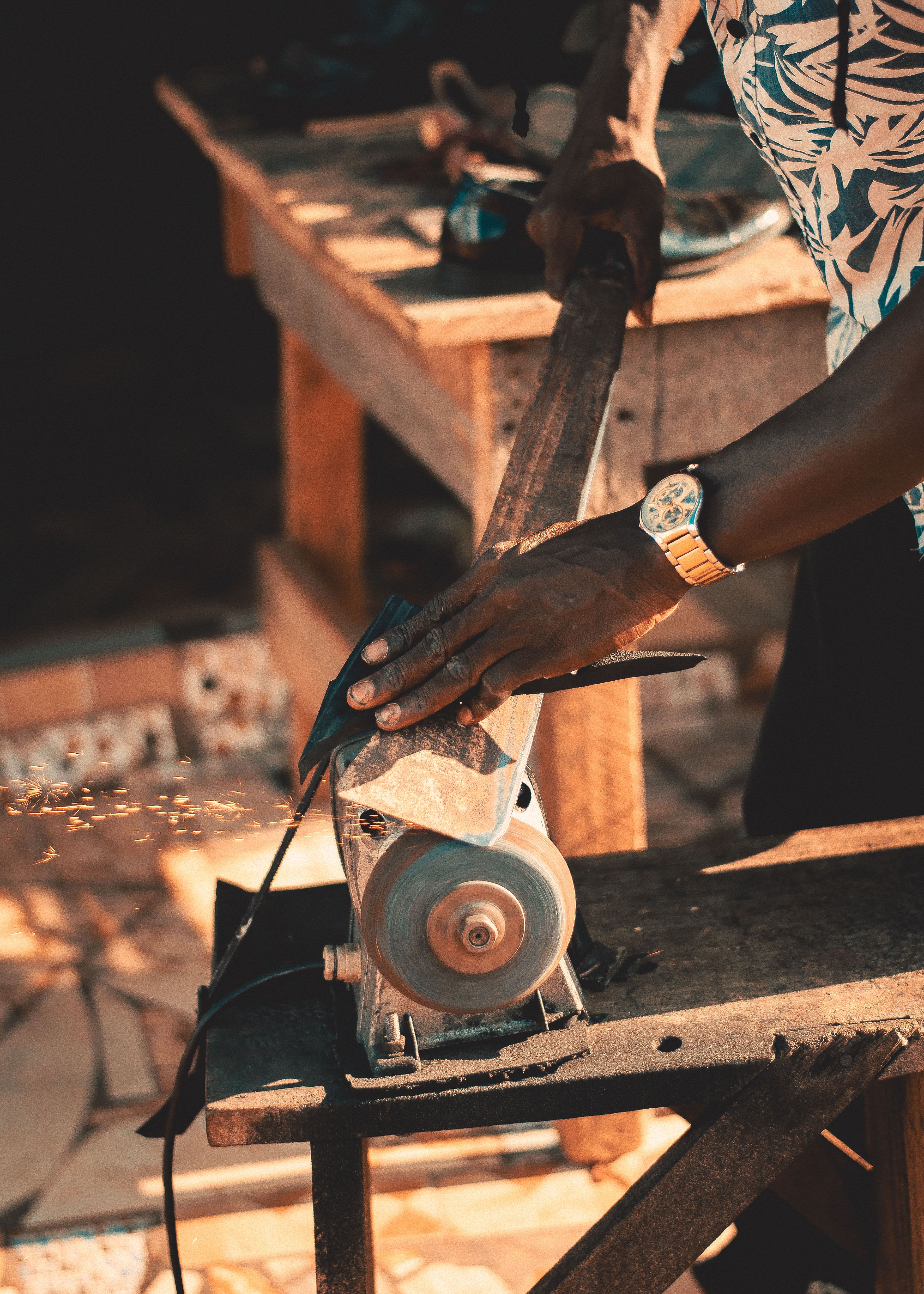 Man Using a Grinder to Make a Tool · Free Stock Photo