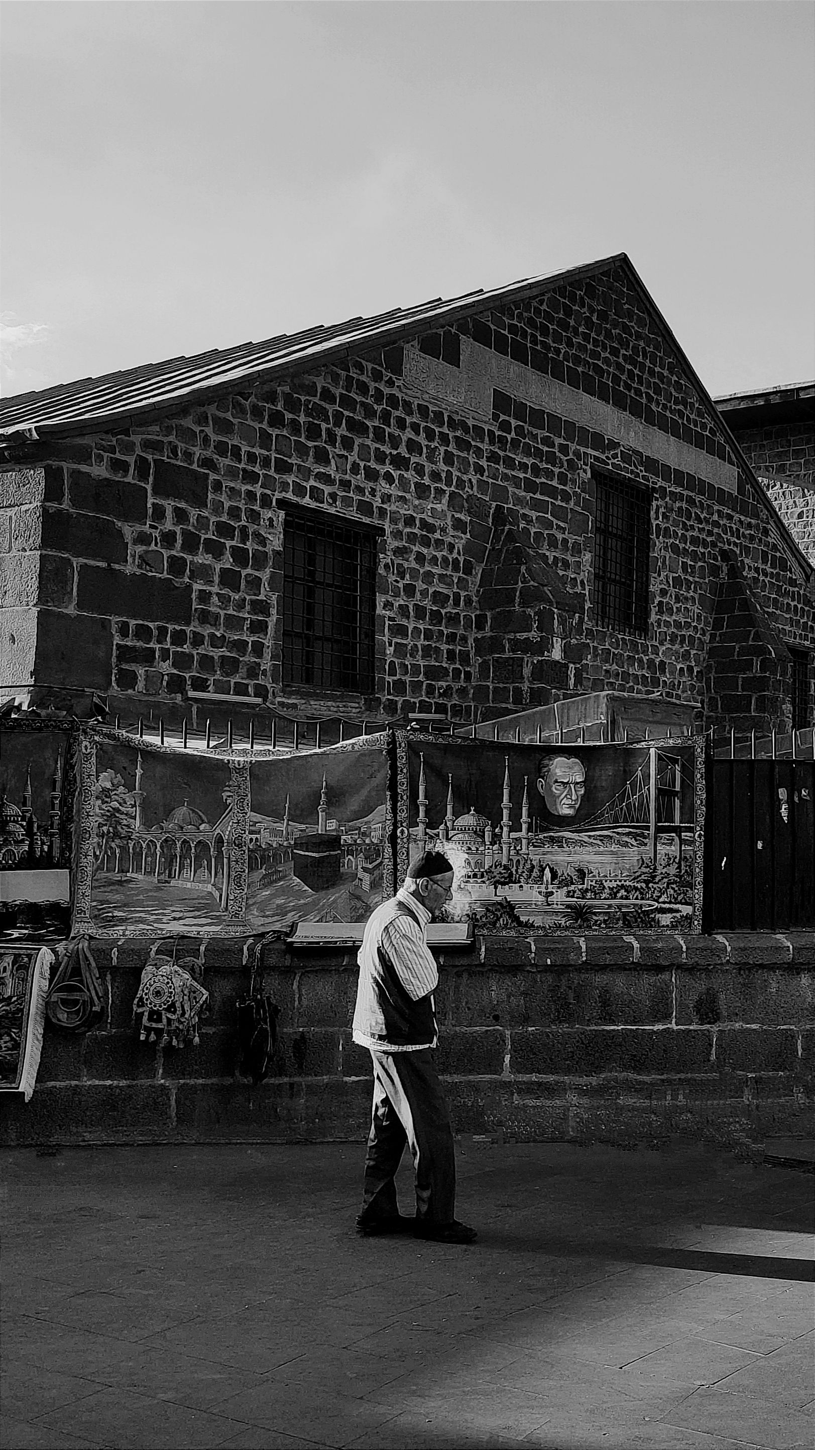 Black and White Photo of a Man Walking by a Wall · Free Stock Photo