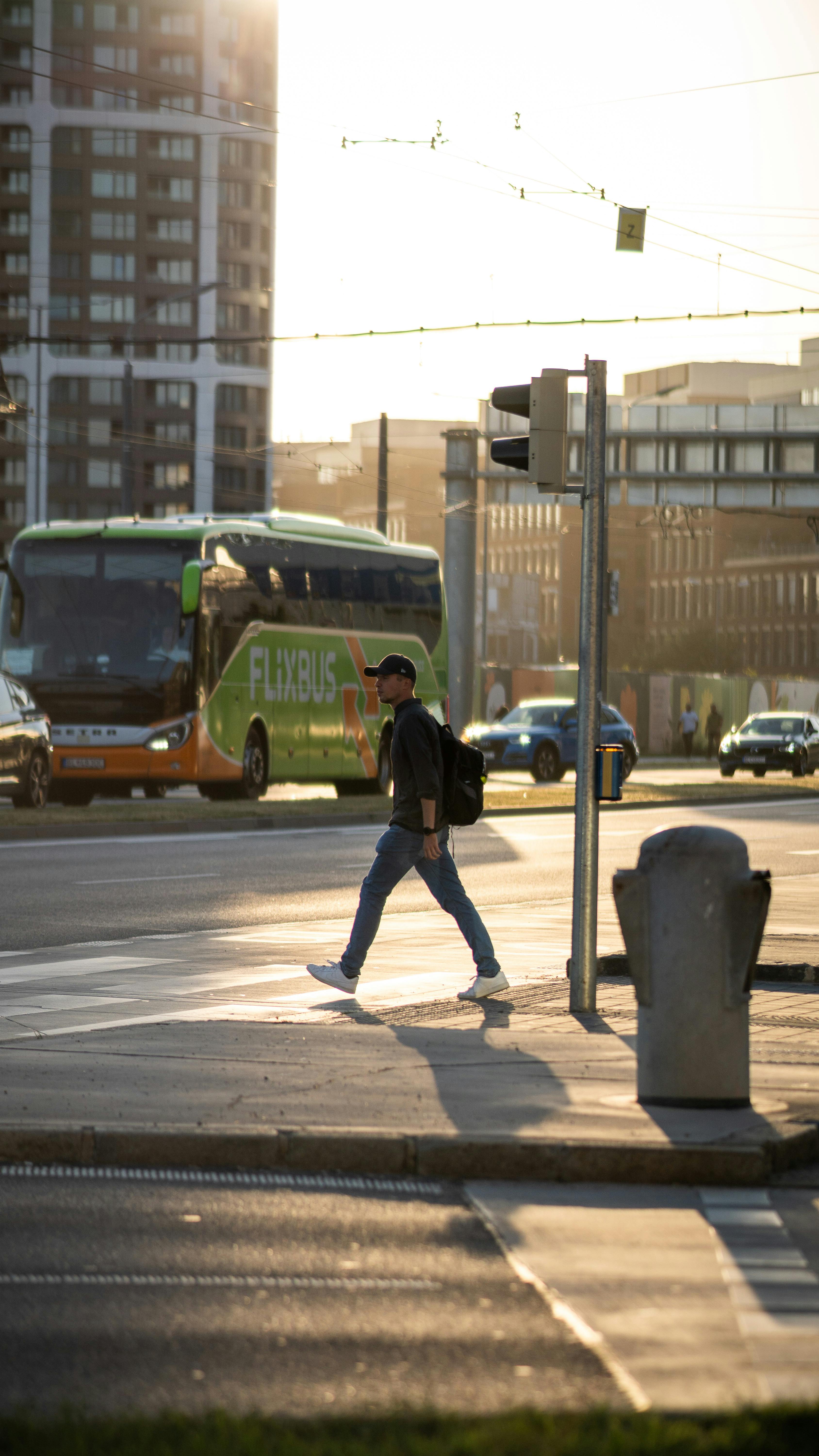 Man with Backpack Walking to Bus Stop · Free Stock Photo