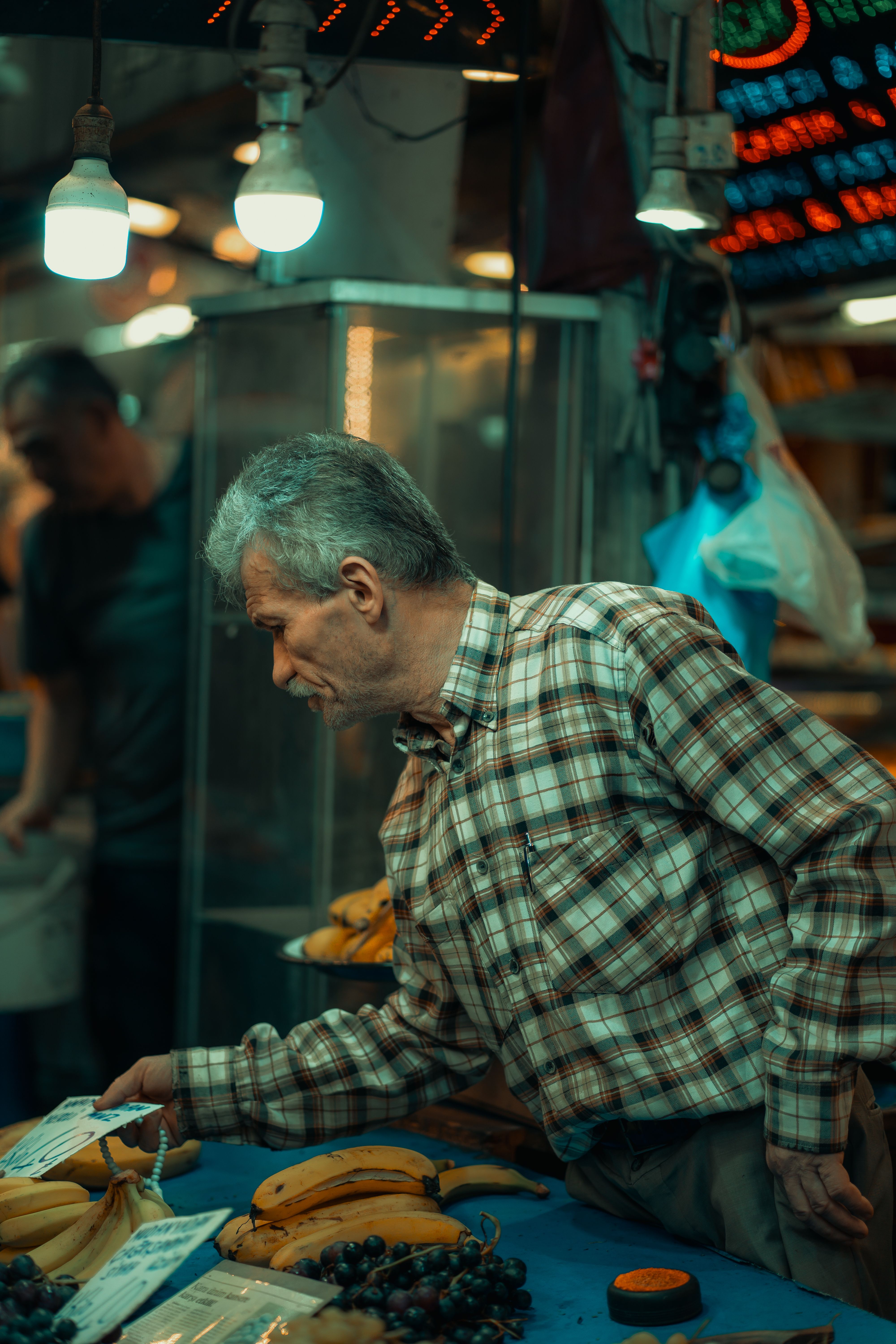 Man in Cap and Jacket Standing Between Stalls at Market · Free Stock Photo