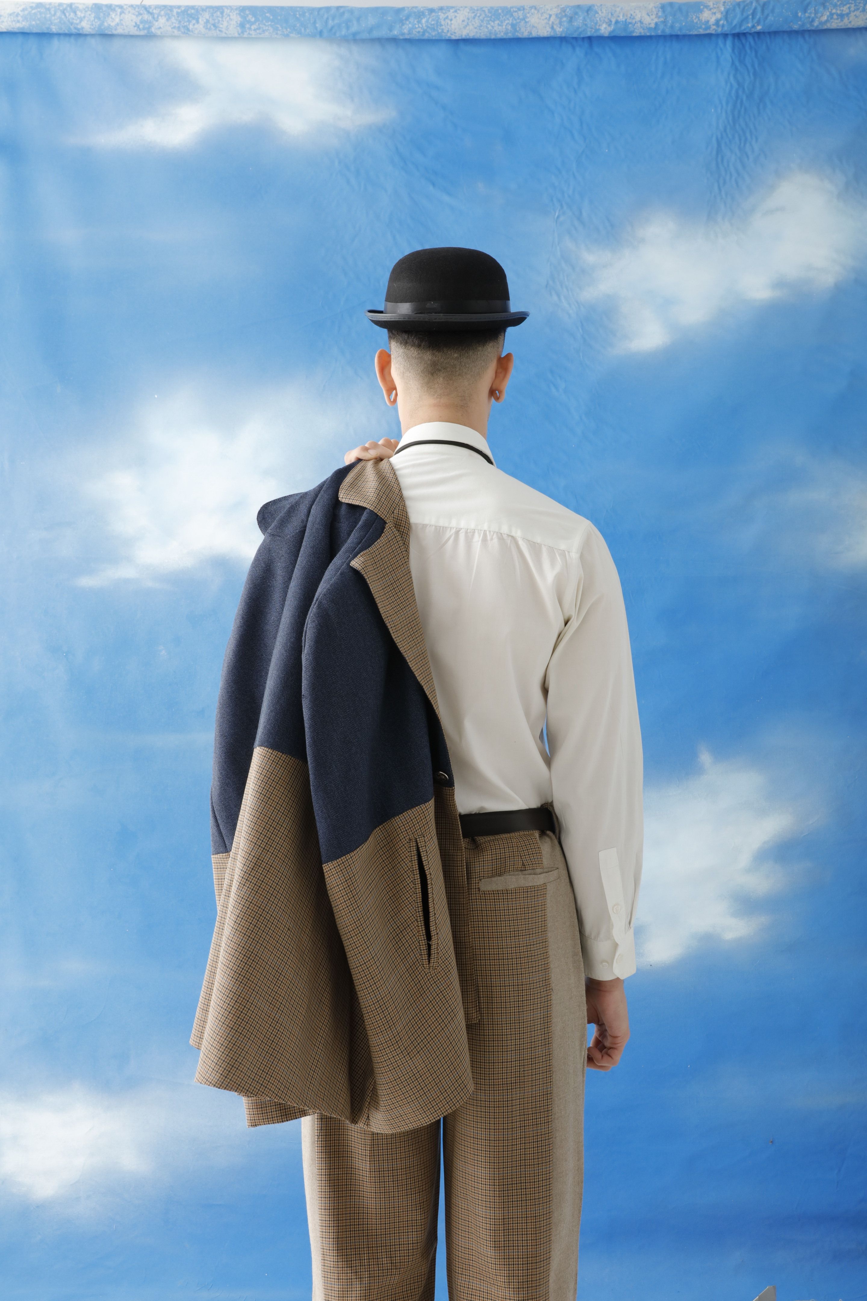 Back View of Person Wearing Bowler Hat Posing in a Suit · Free Stock Photo