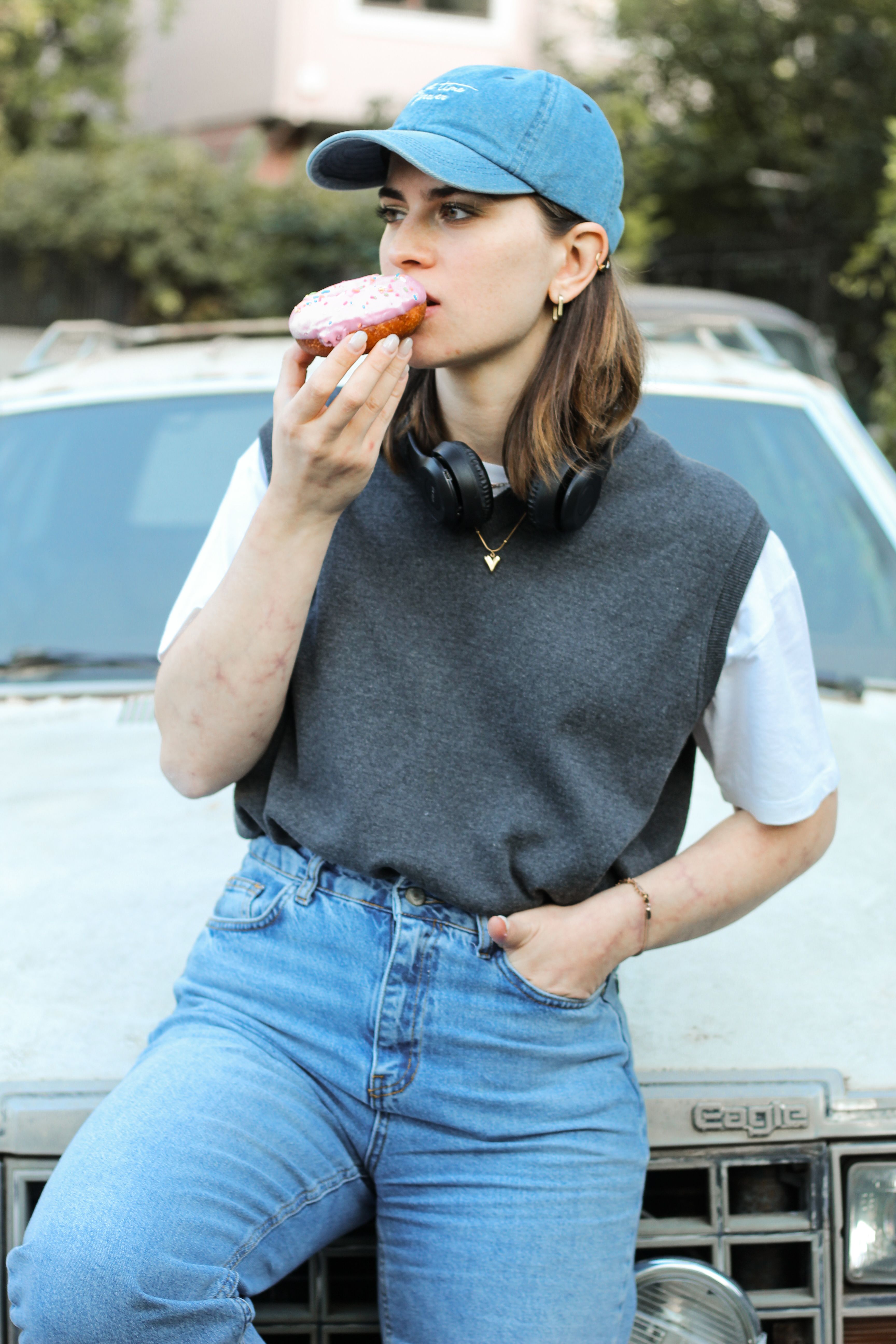 Woman Standing and Eating Donut · Free Stock Photo