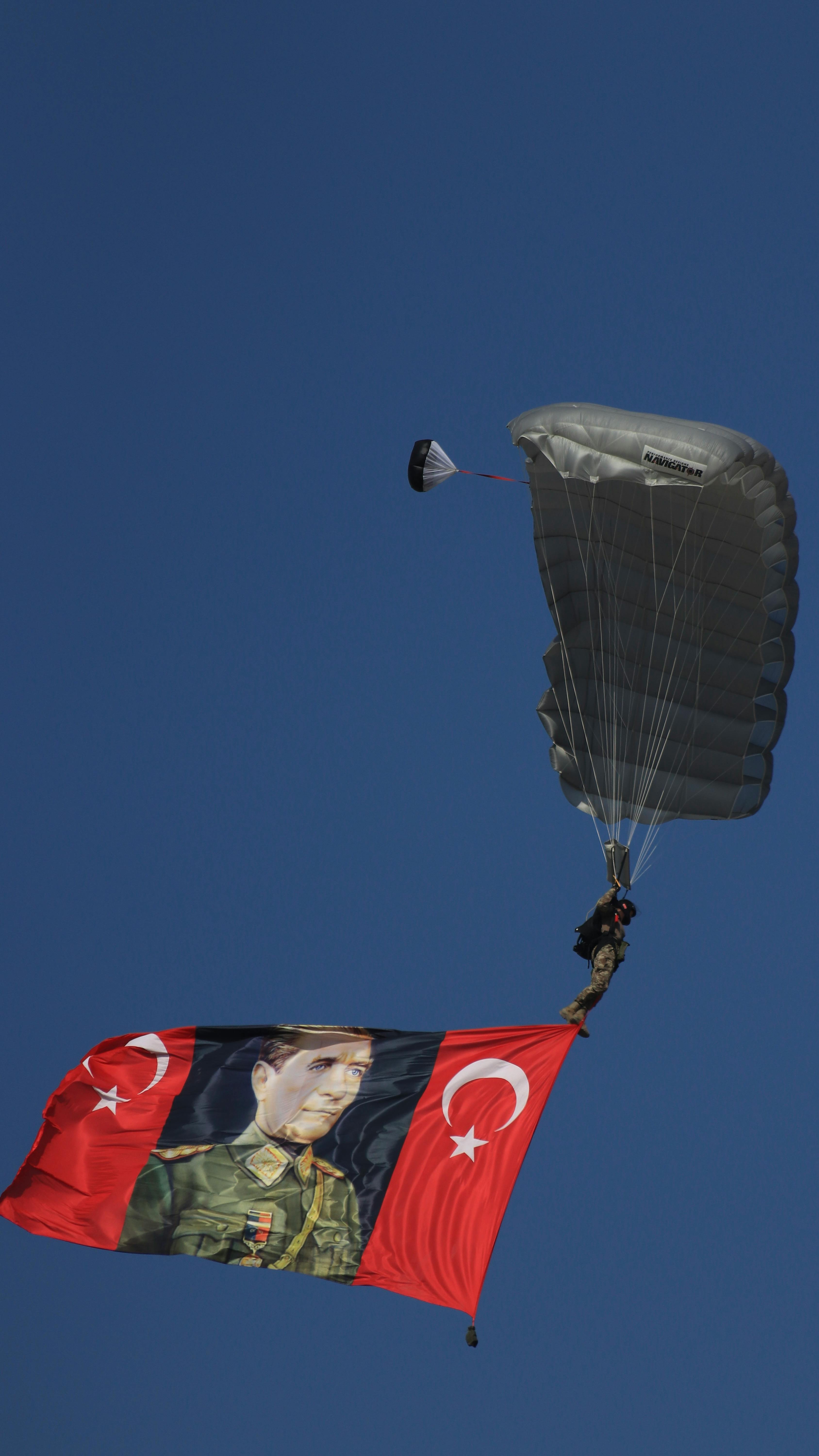 Person With a Parachute Holding a Turkish Flag with an Image of a Man ...