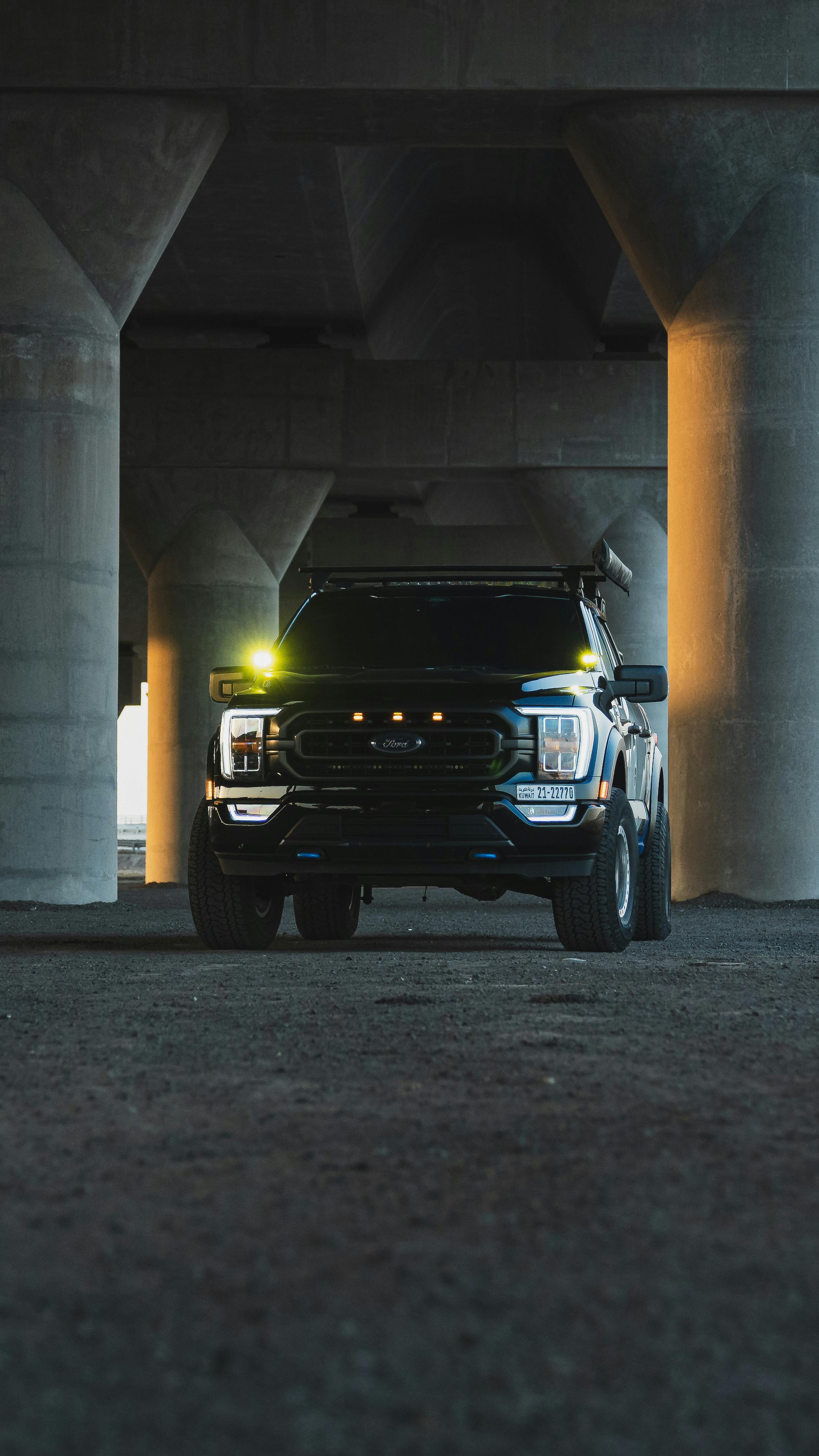 Black SUV between Bridge Columns · Free Stock Photo