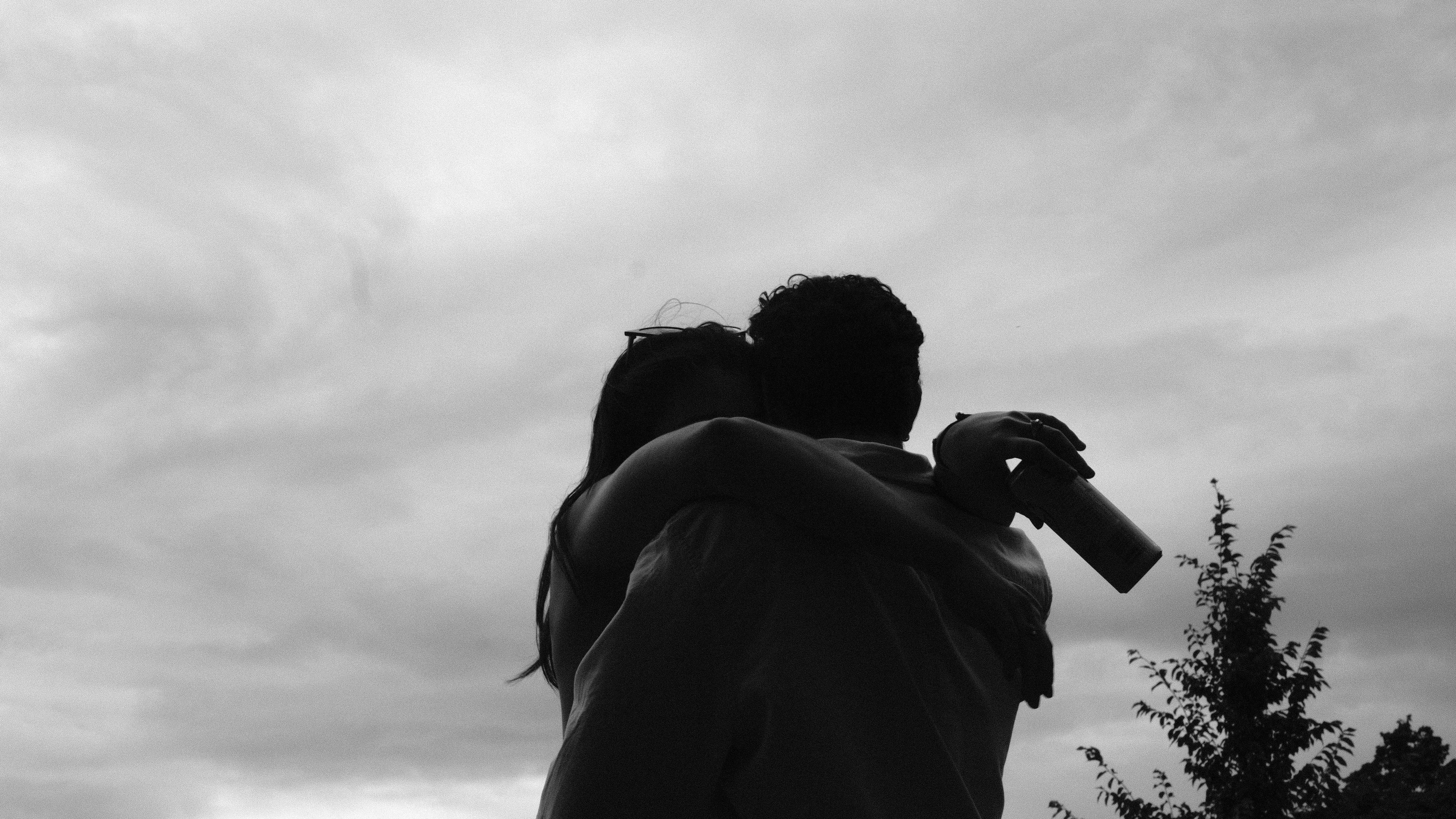 Hugging Couple under Clouds · Free Stock Photo