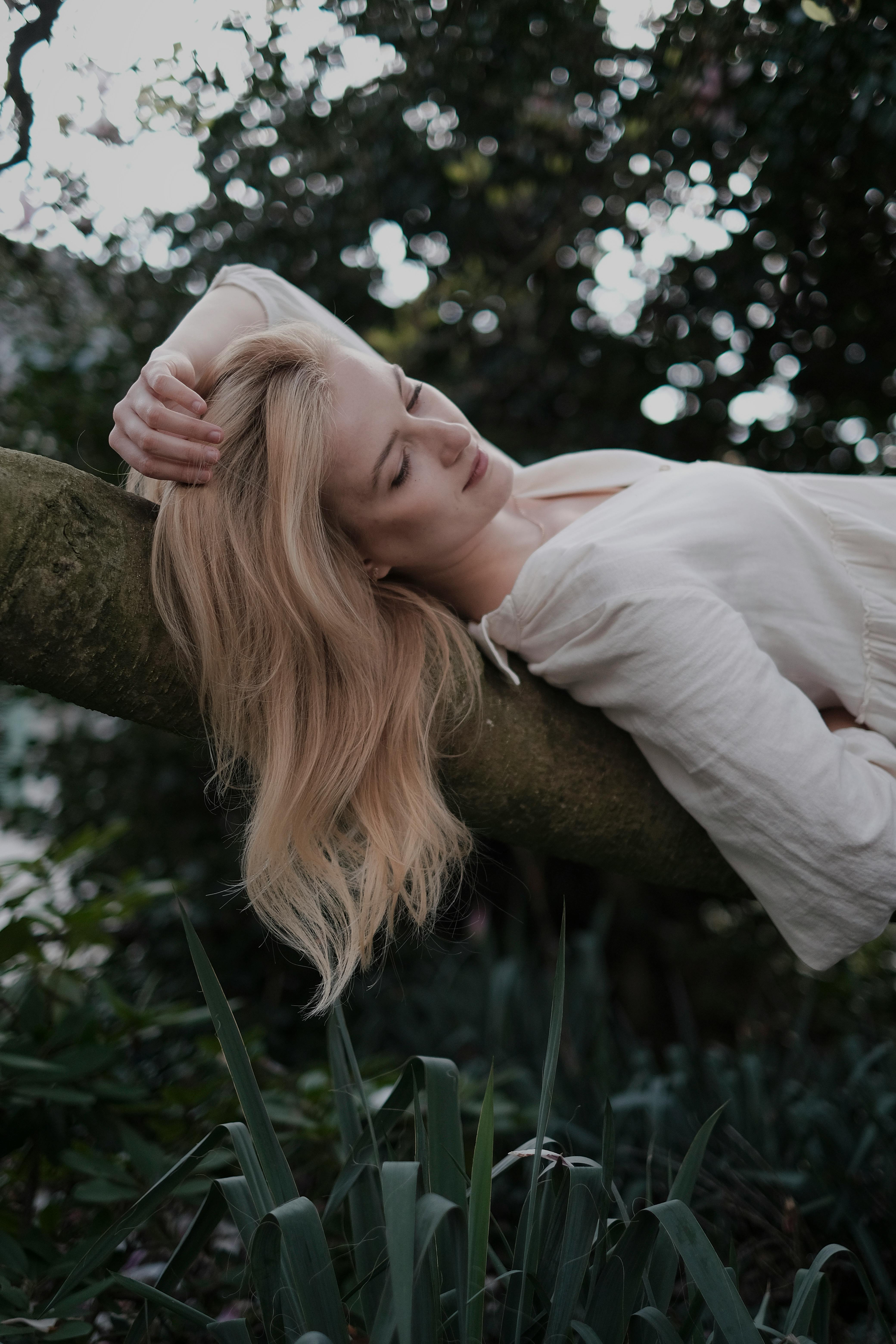 Serene Woman Lying on Tree in Nature · Free Stock Photo