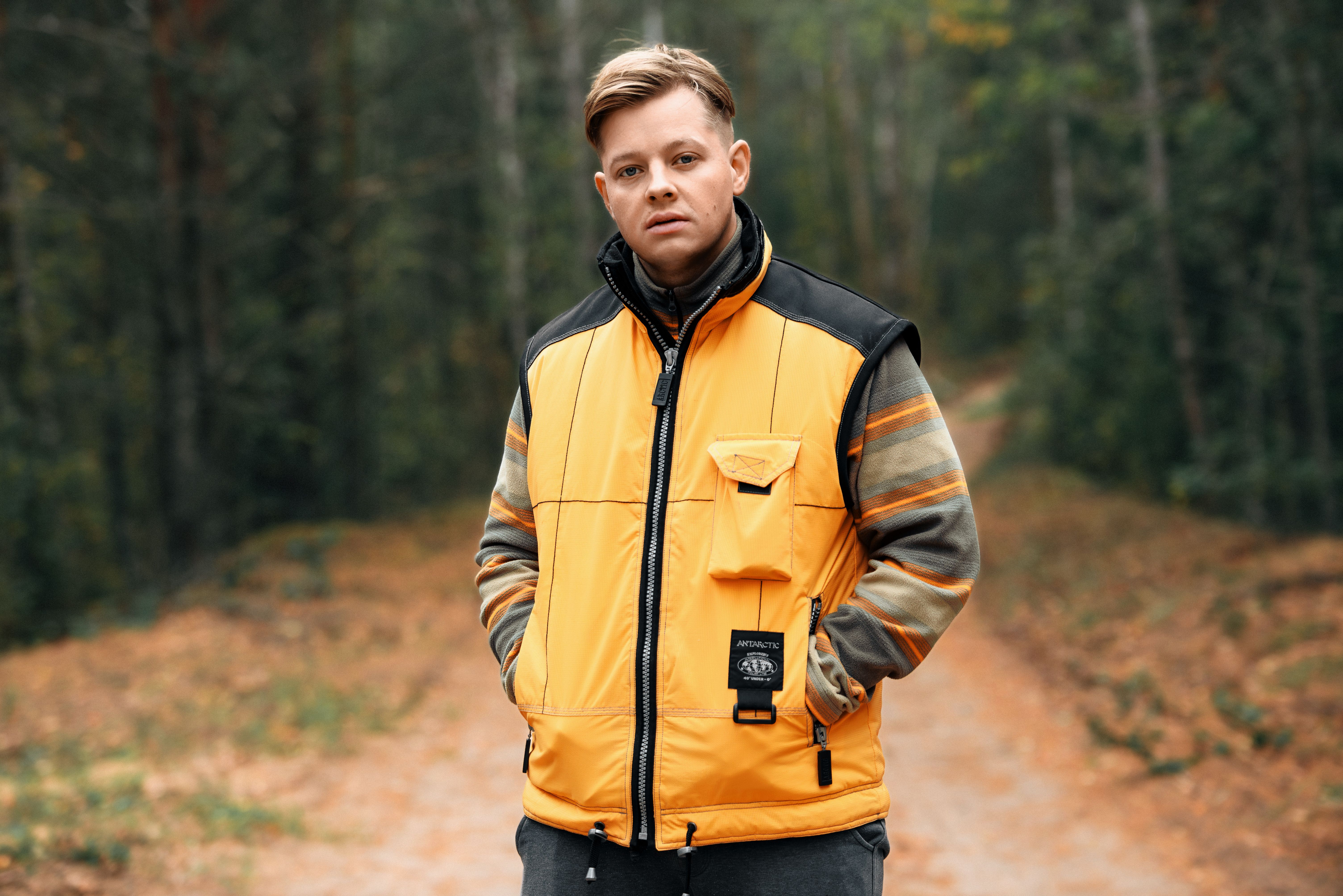 Man in Yellow Vest Standing with Hands in Pockets · Free Stock Photo