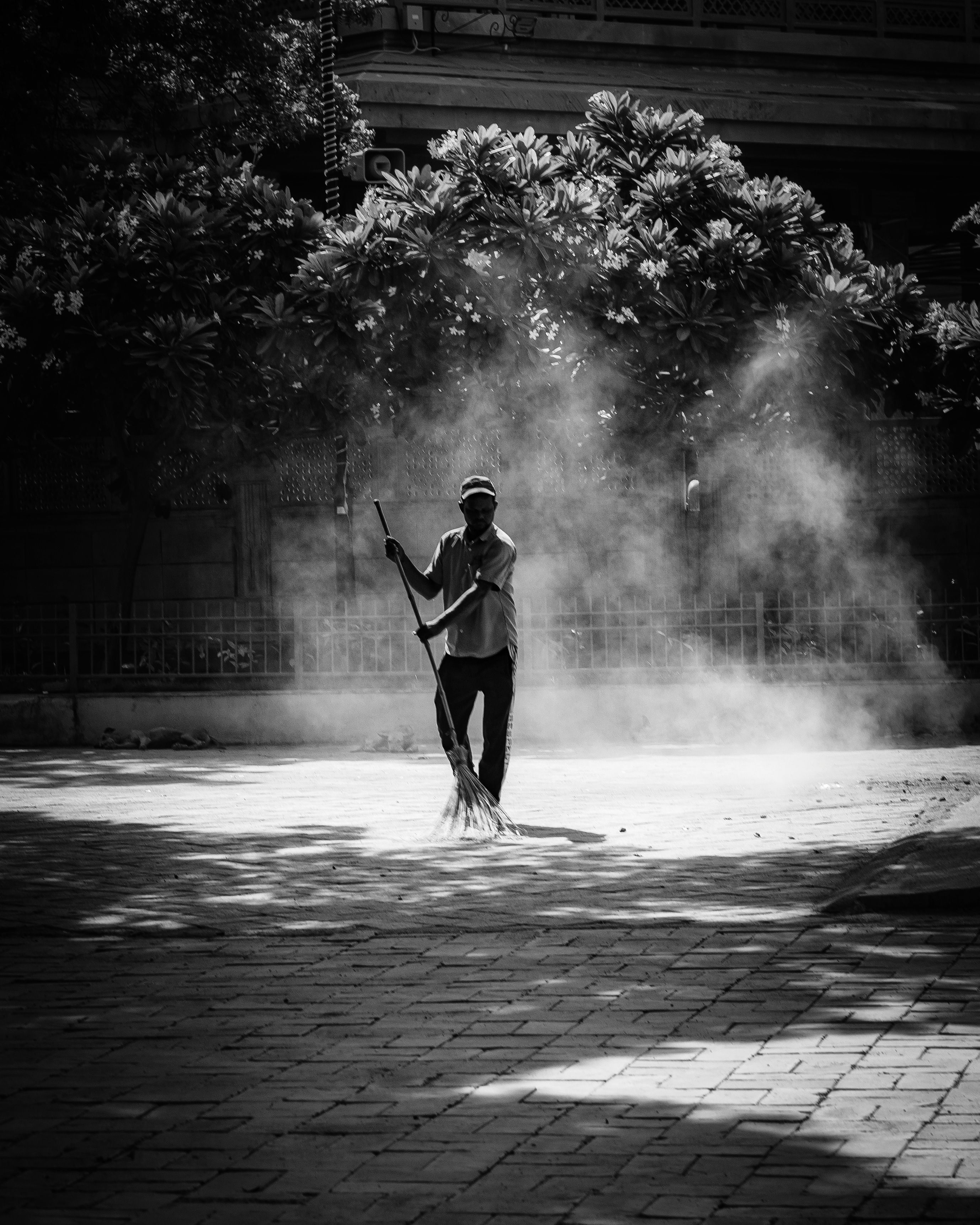 Man Cleaning Pavement with Broom in Black and White · Free Stock Photo