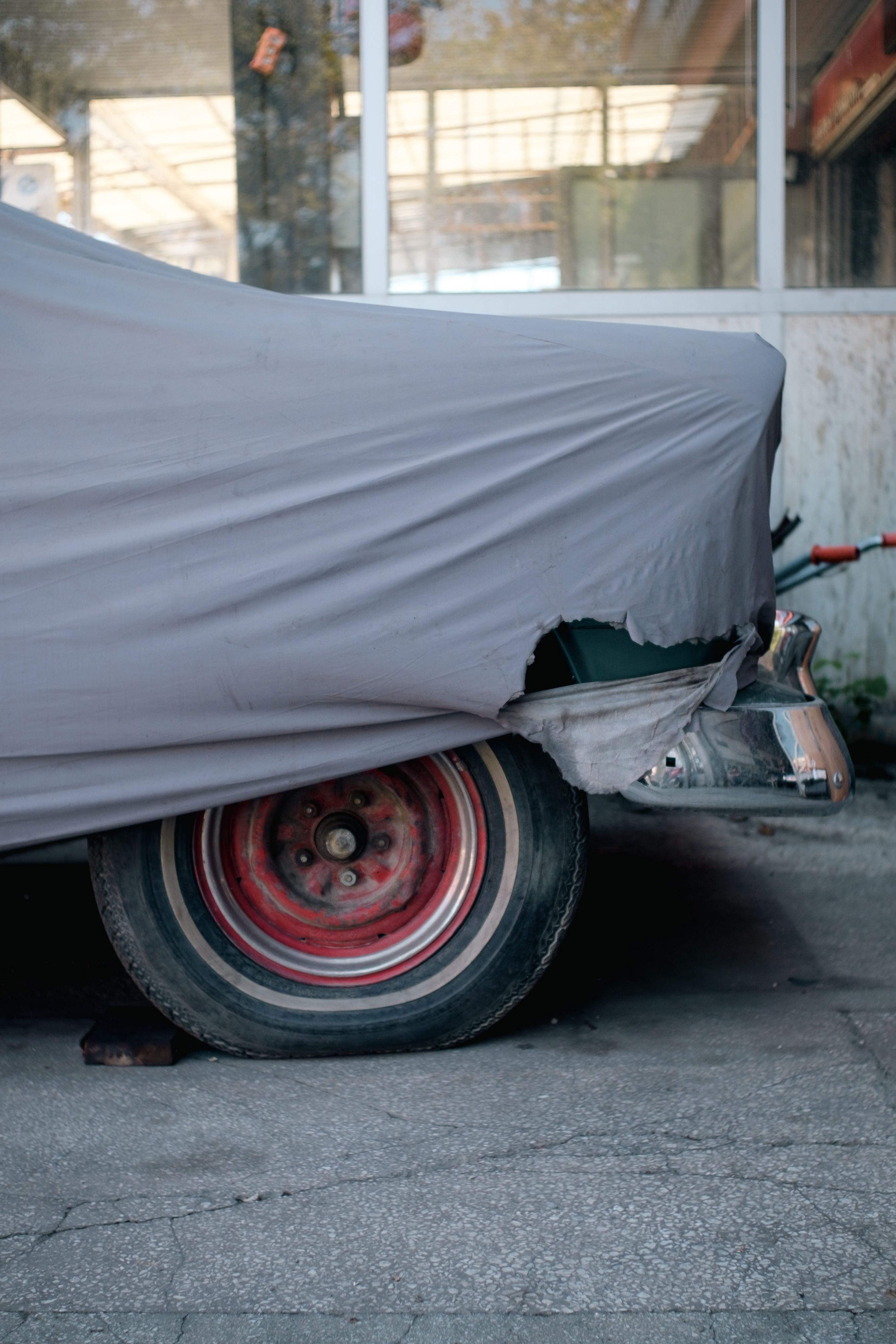 A car covered in a tarp with a tire on it · Free Stock Photo