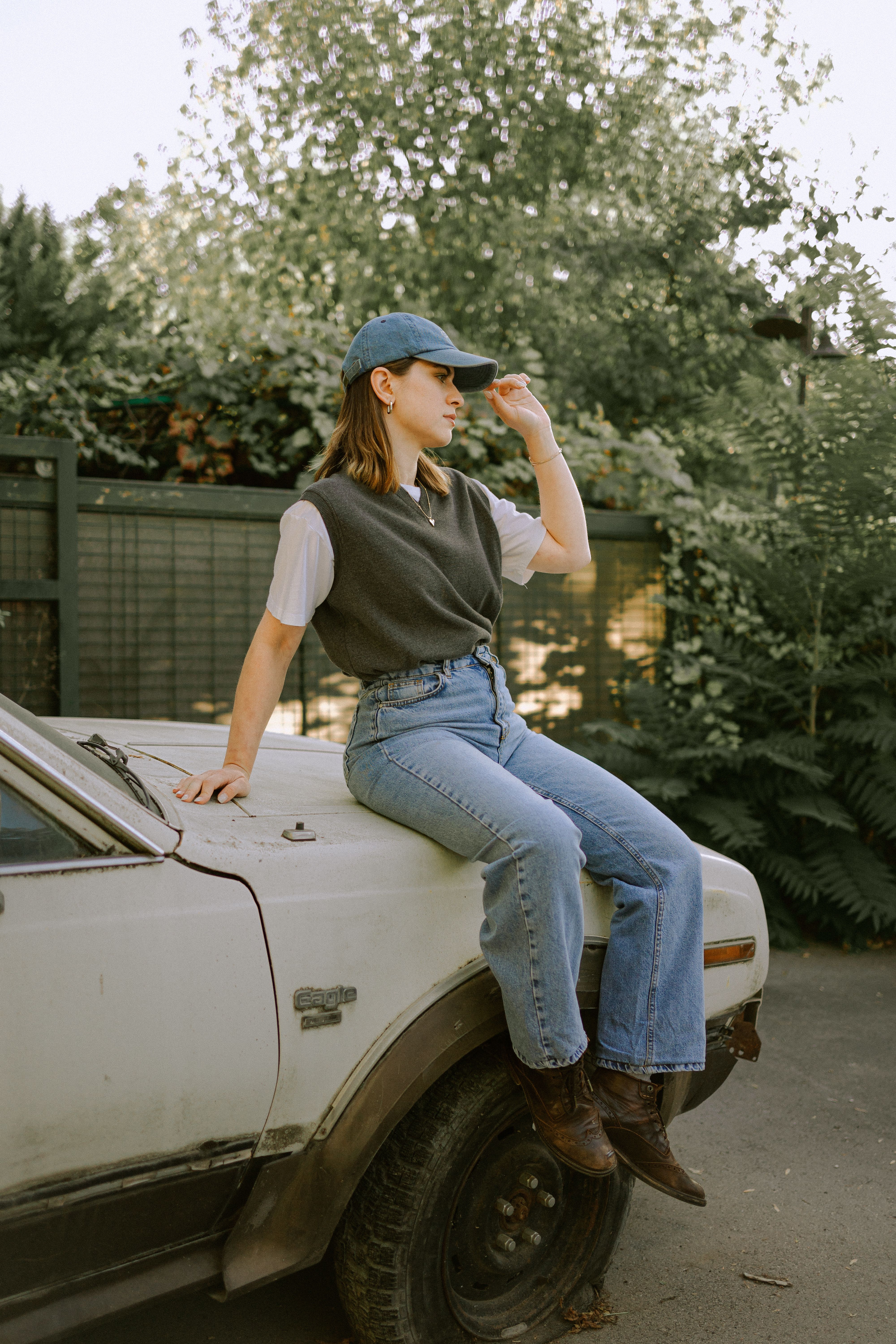 Girl in Bucket Hat Sitting on a Car Hood · Free Stock Photo