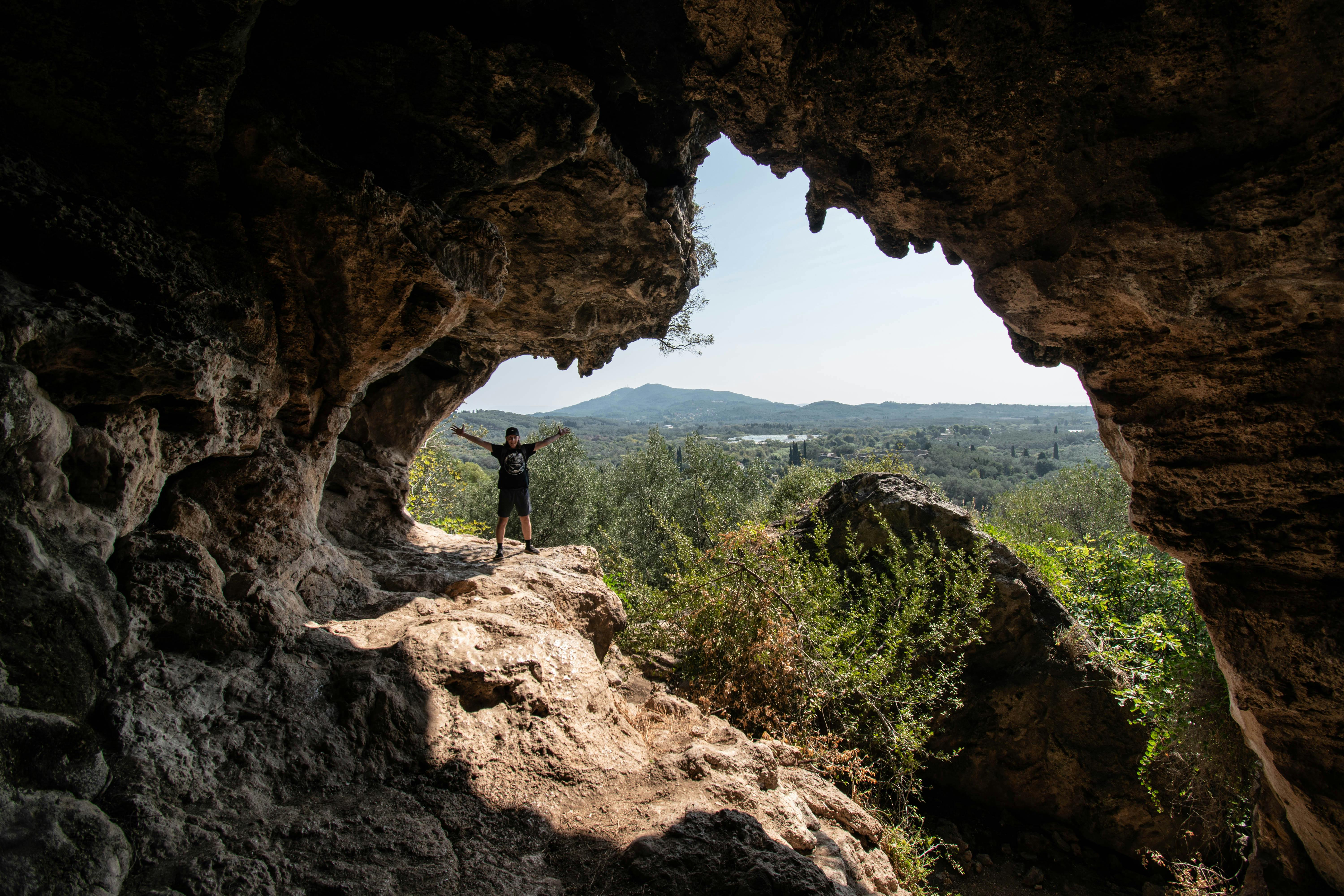 Back view Photo of Person Walking Out of a Cave · Free Stock Photo