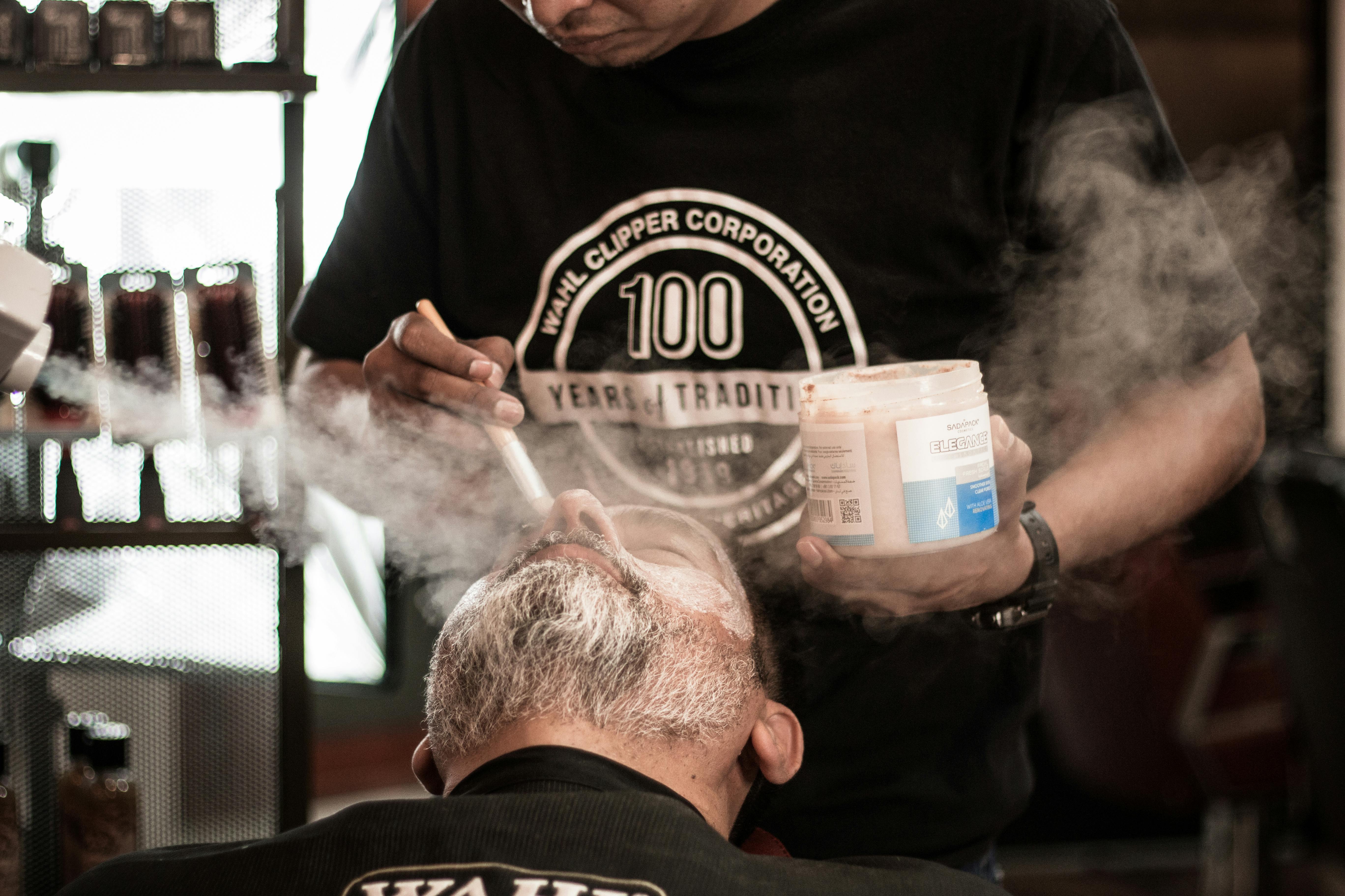 A Barber Brushing Powder on a Mans Beard · Free Stock Photo