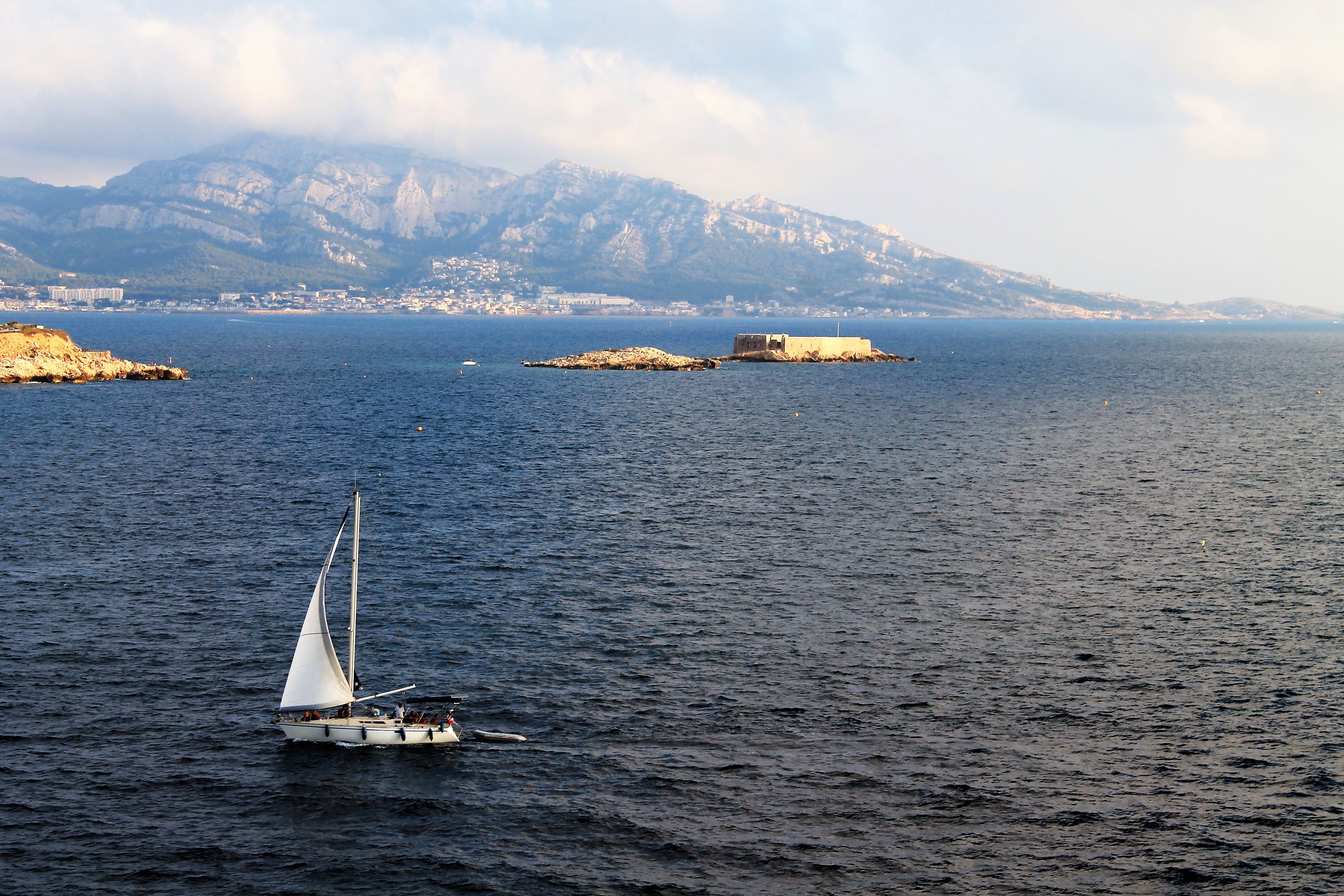 Sailboat Sailing on Sea Coast with Islands · Free Stock Photo