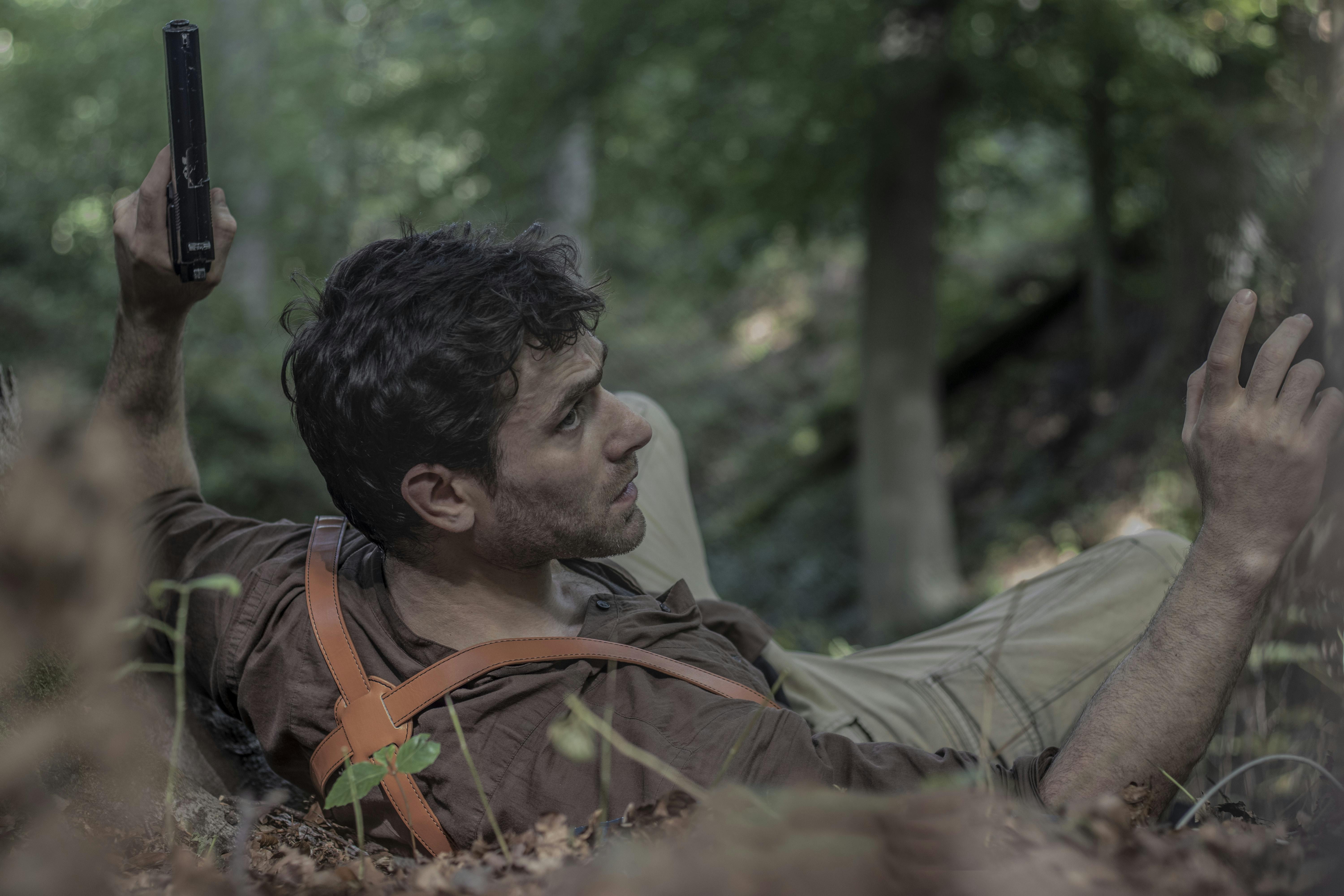 Man Lying on the Ground with a Gun · Free Stock Photo