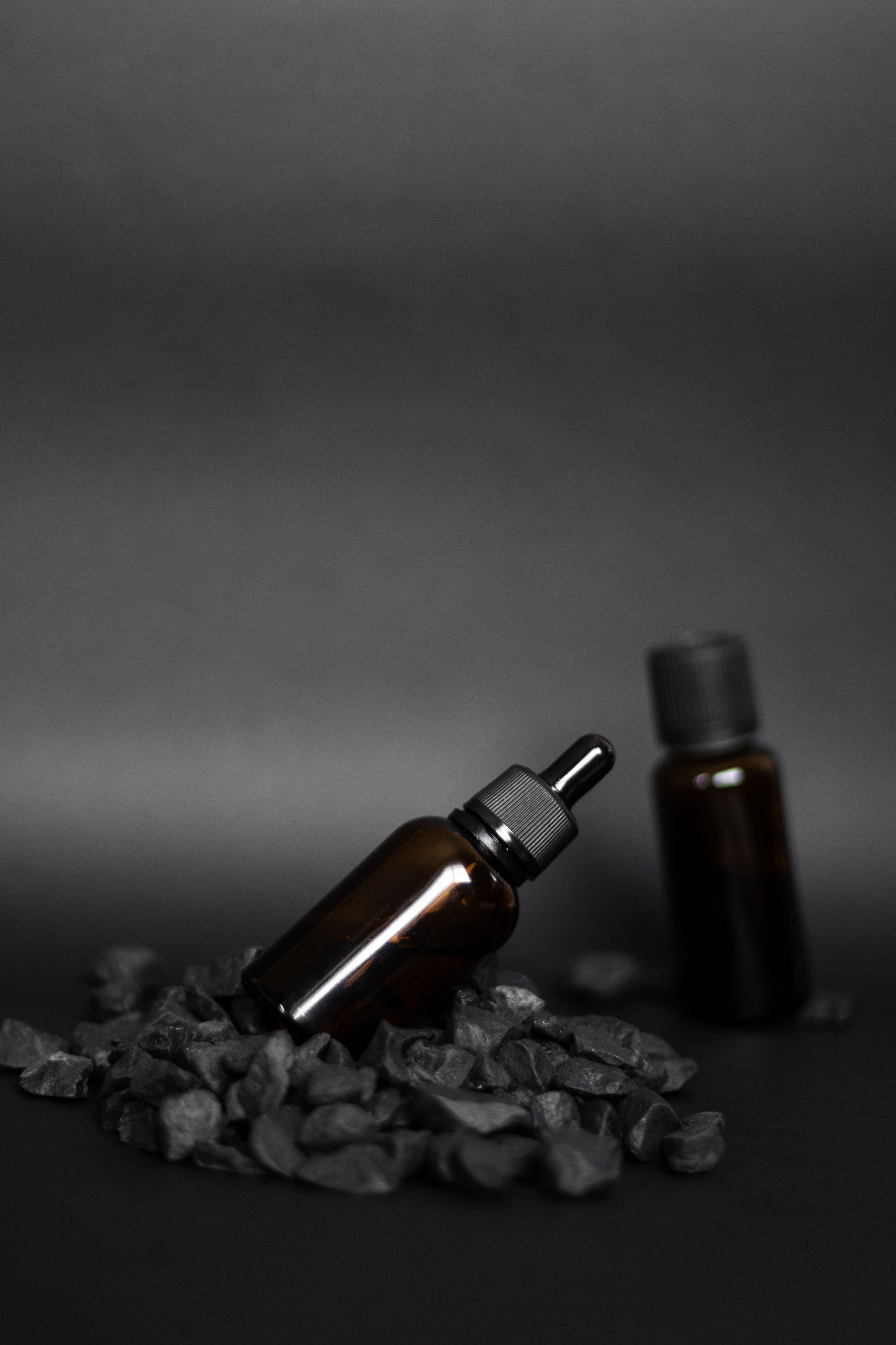 Two bottles of essential oil on a black background · Free Stock Photo