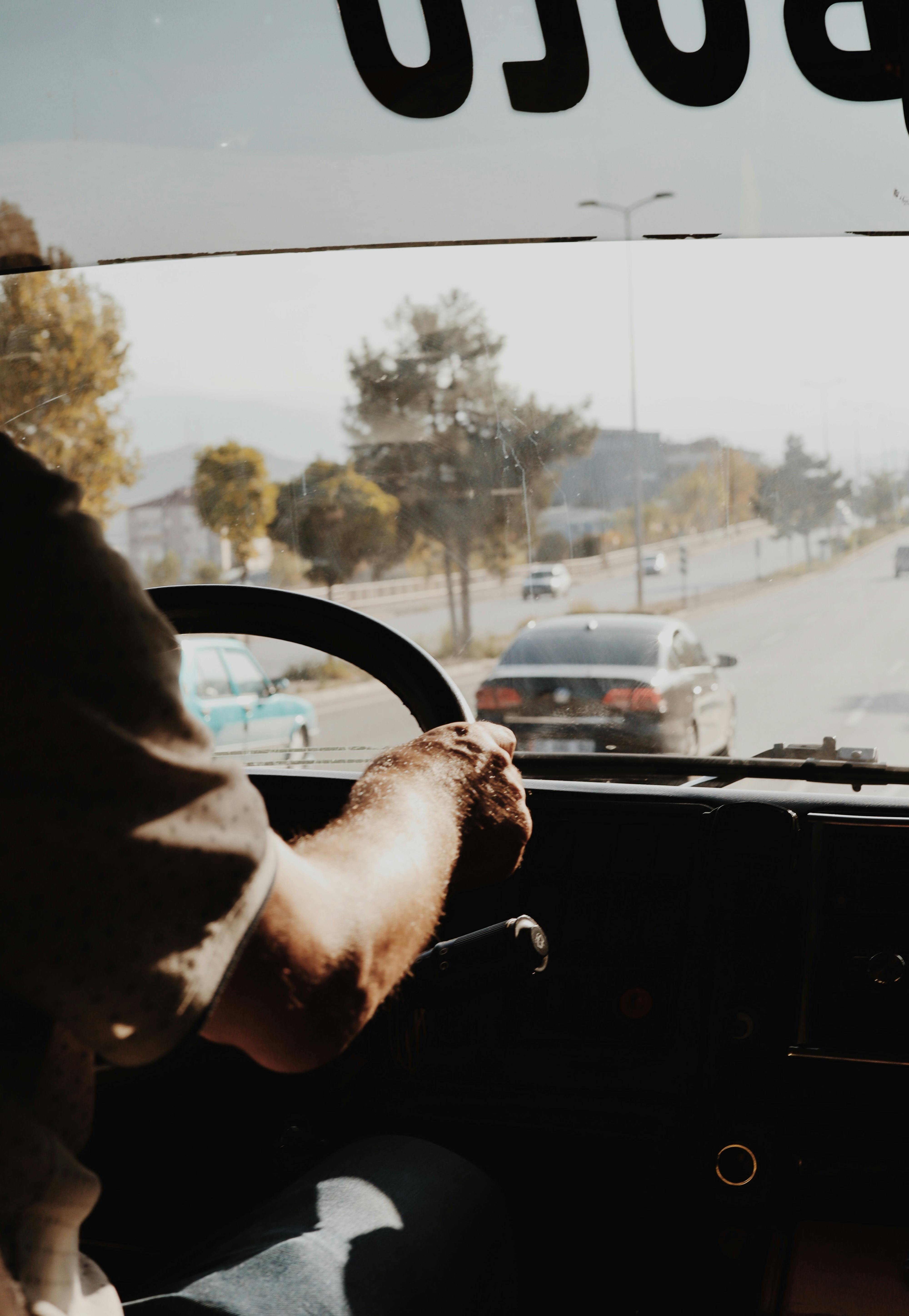 Man Arm on Steering Wheel · Free Stock Photo