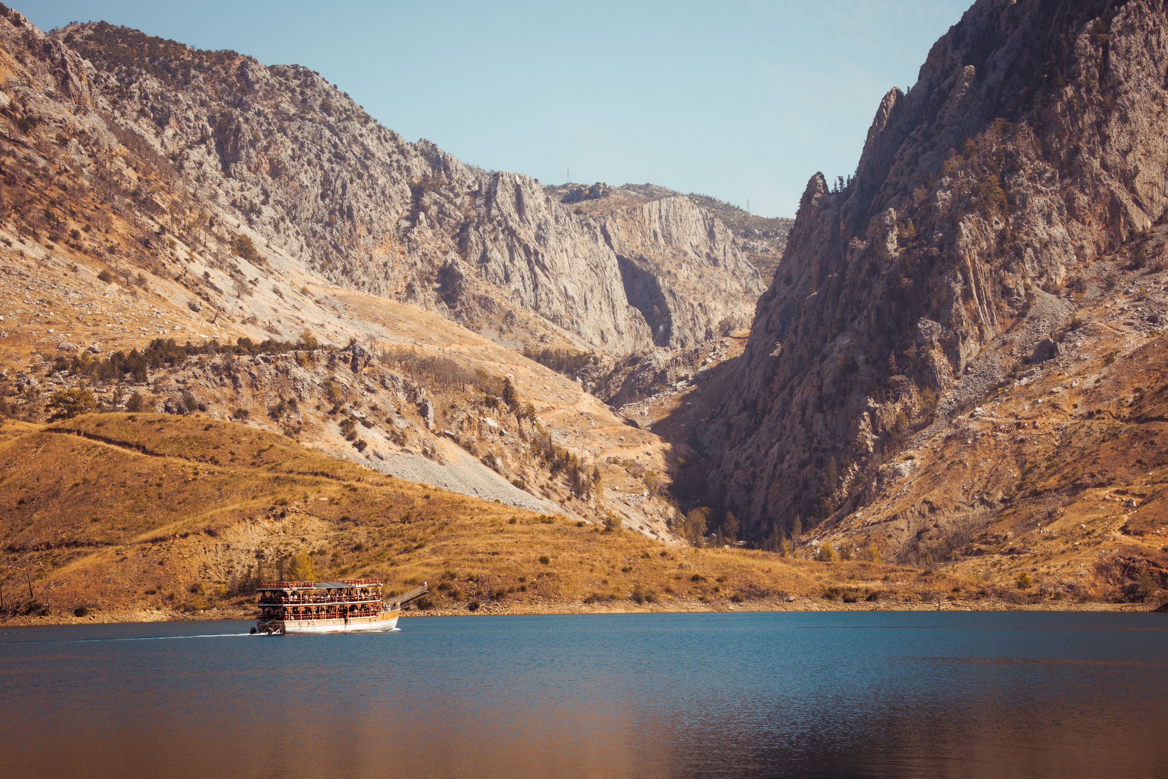 Passenger Ship on Lake with Rocky Hill behind · Free Stock Photo