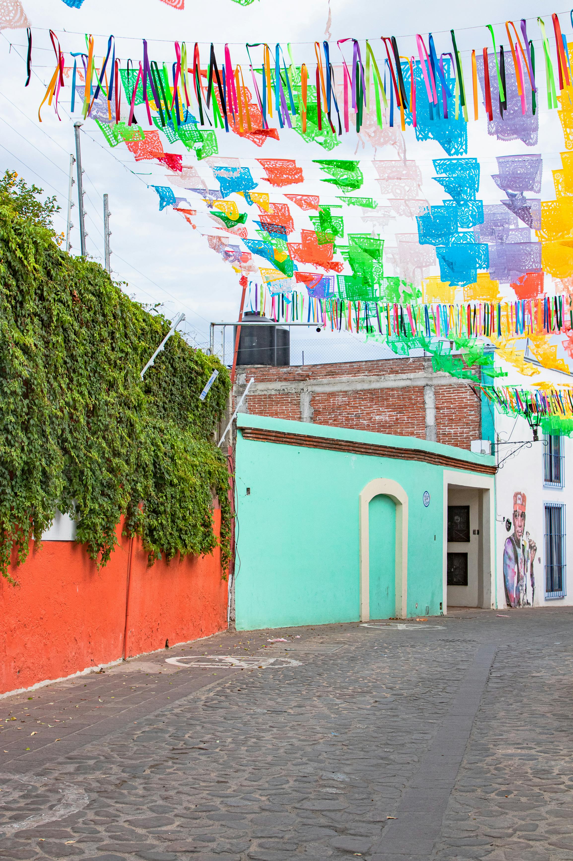 Colorful Decorations over the Cobblestone Alley of Mexican City Oaxaca ...