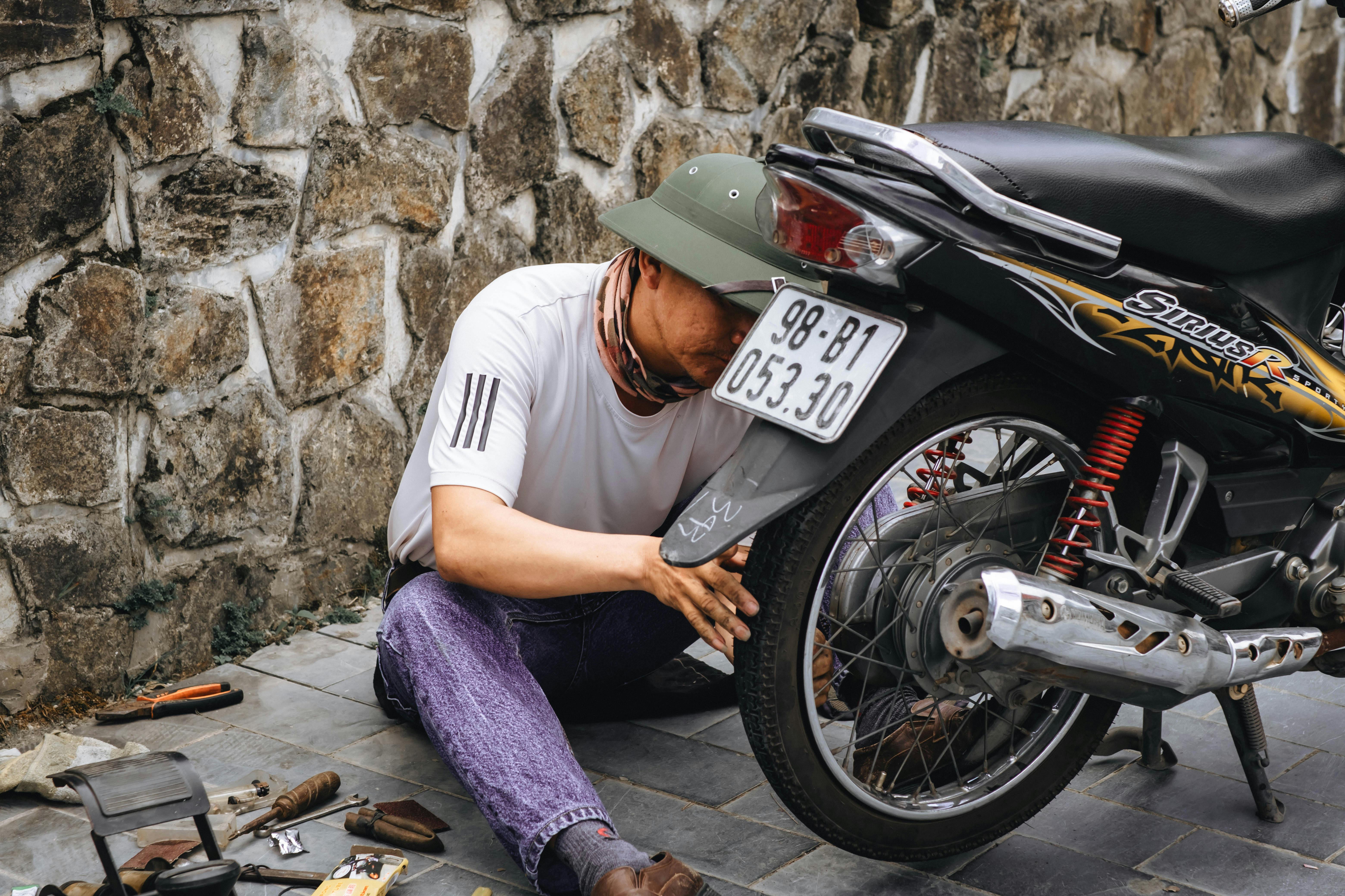 Close-Up Shot of a Person Fixing an Engine of a Motorcycle · Free Stock ...