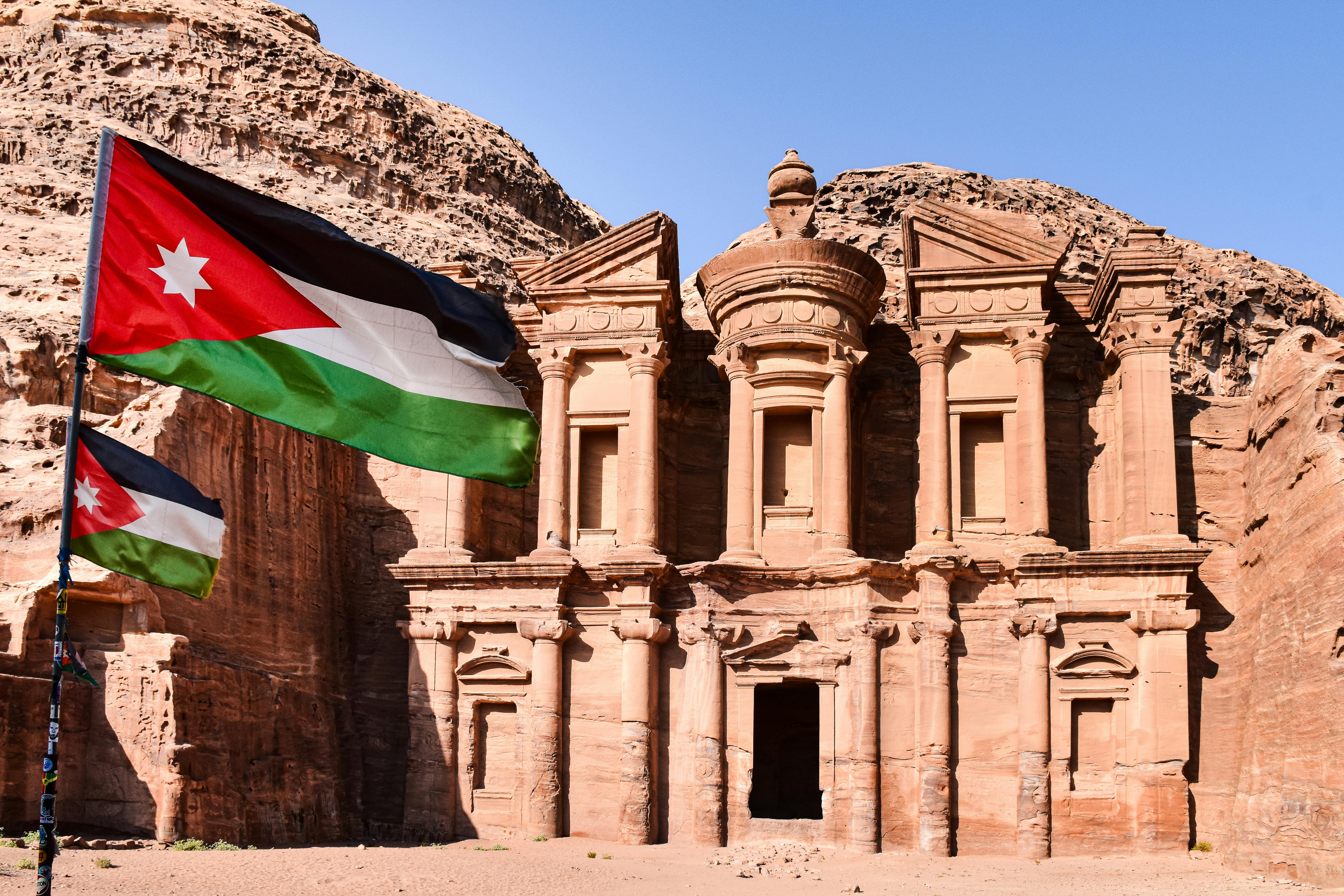 Jordan Flags Flying in Front of Rock-Carved Petra Monastery · Free ...