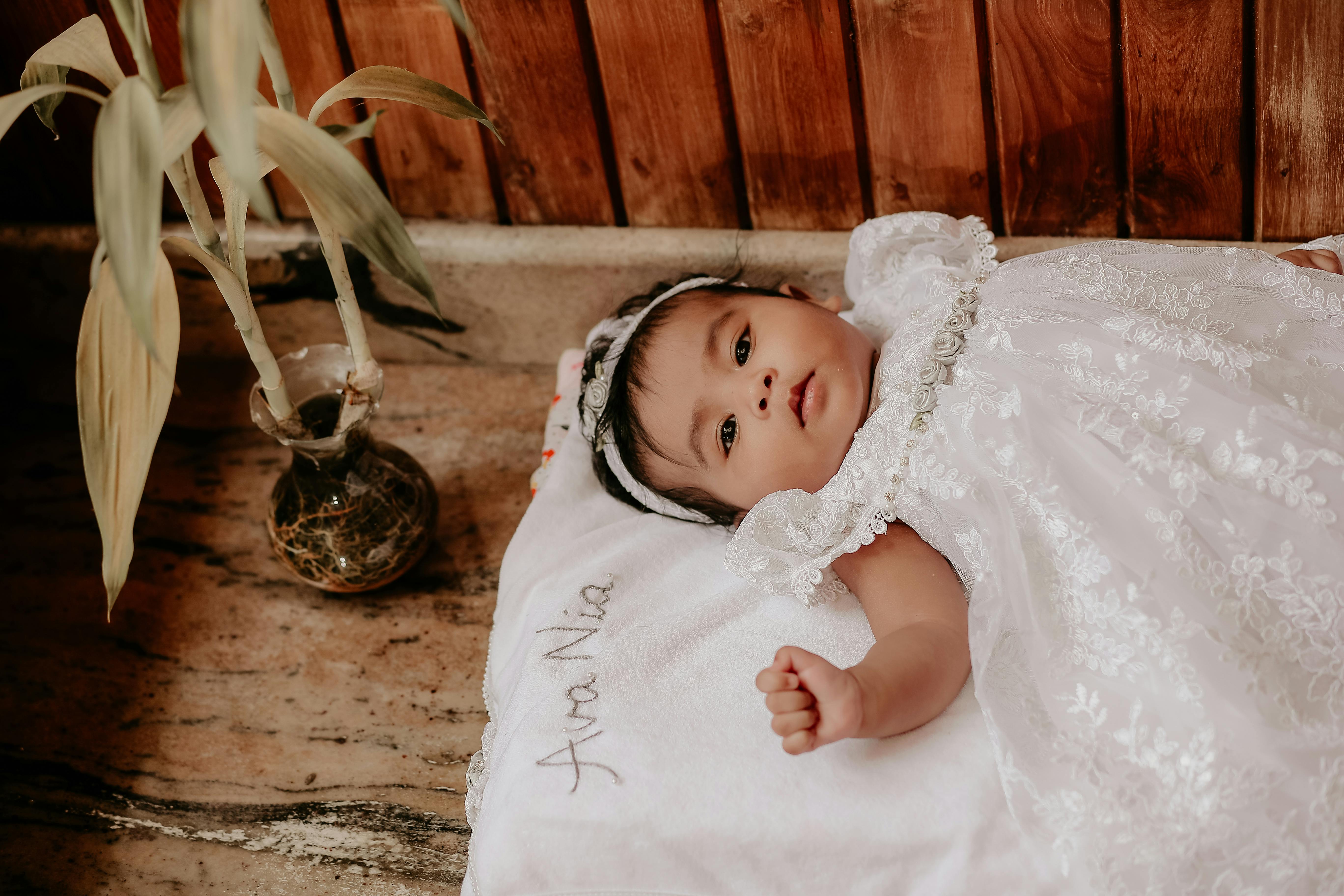 Baby Girl Lying Down near Plant · Free Stock Photo