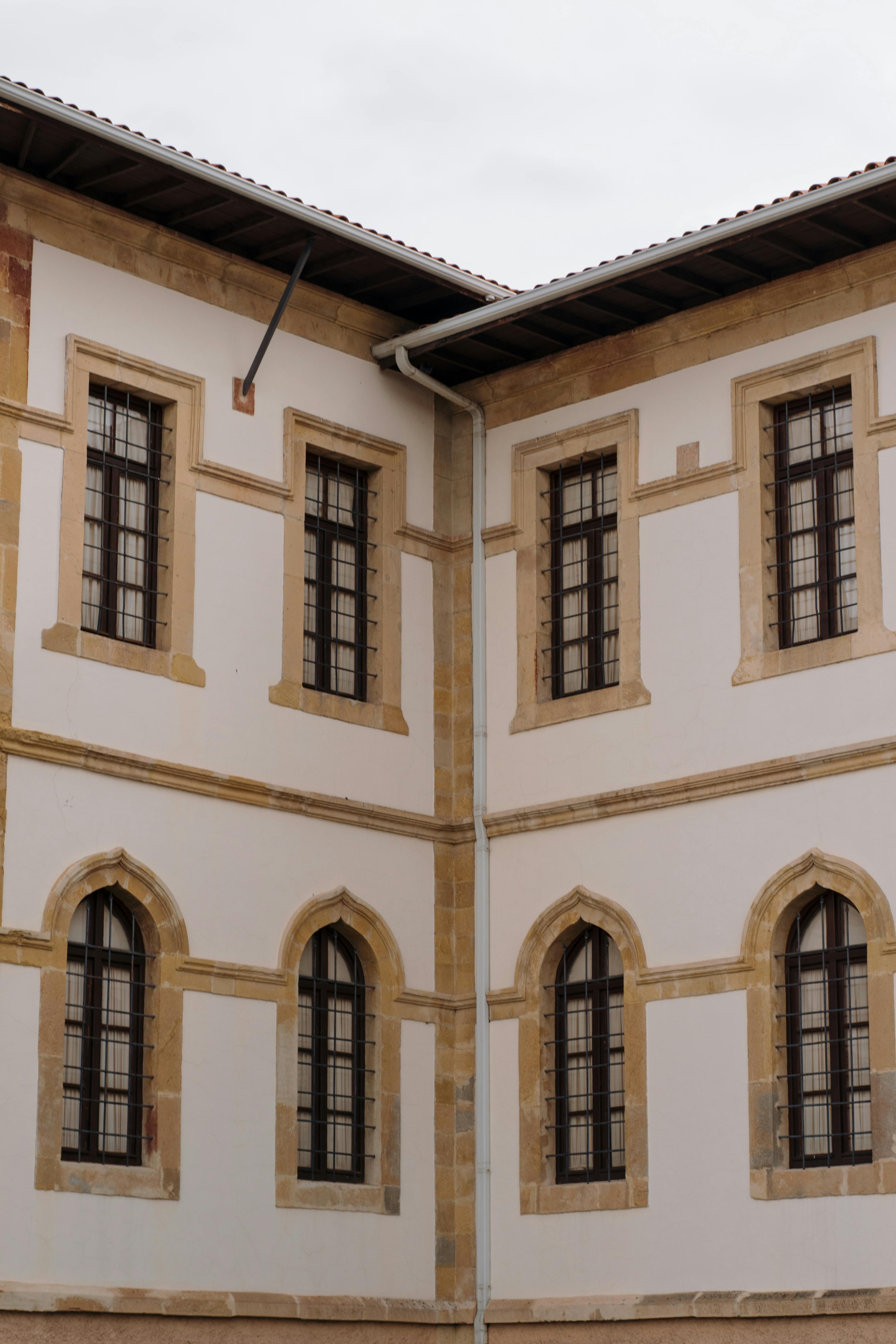 Person Standing near Corner of White, Modern Building · Free Stock Photo