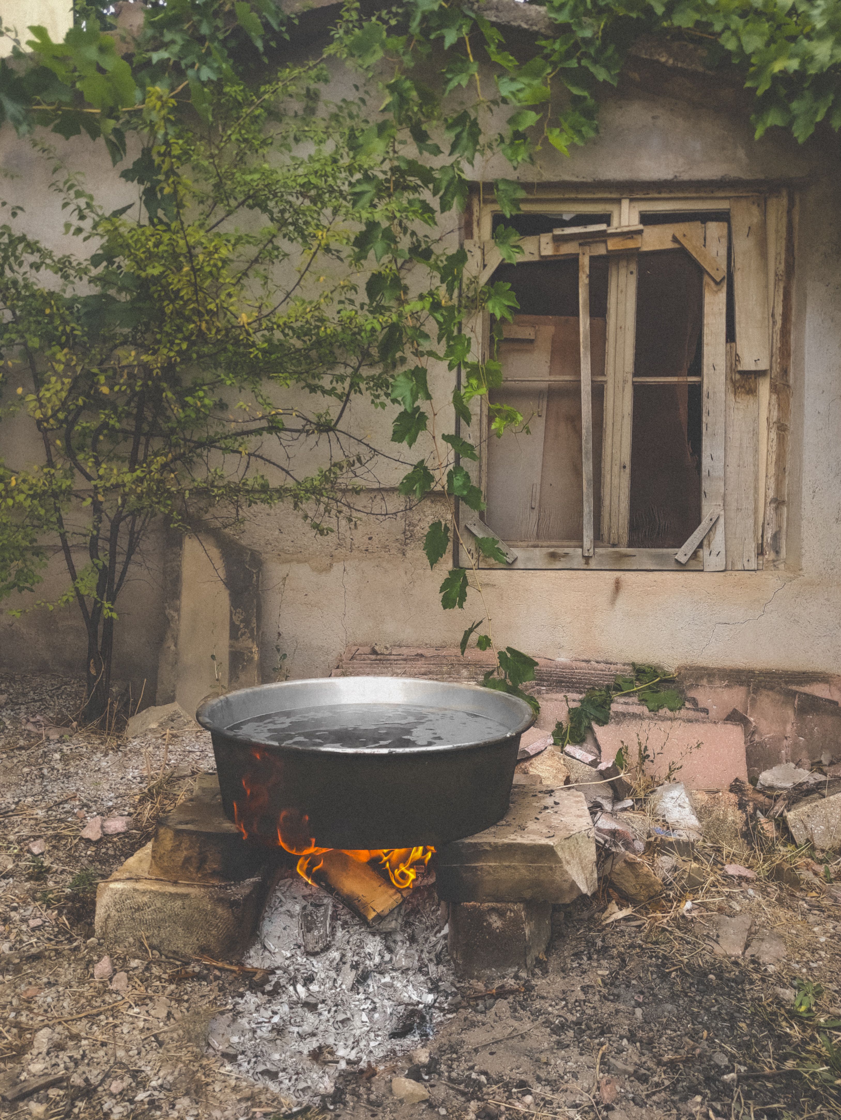 Bonfire Heating Water Bowl near Abandoned House · Free Stock Photo