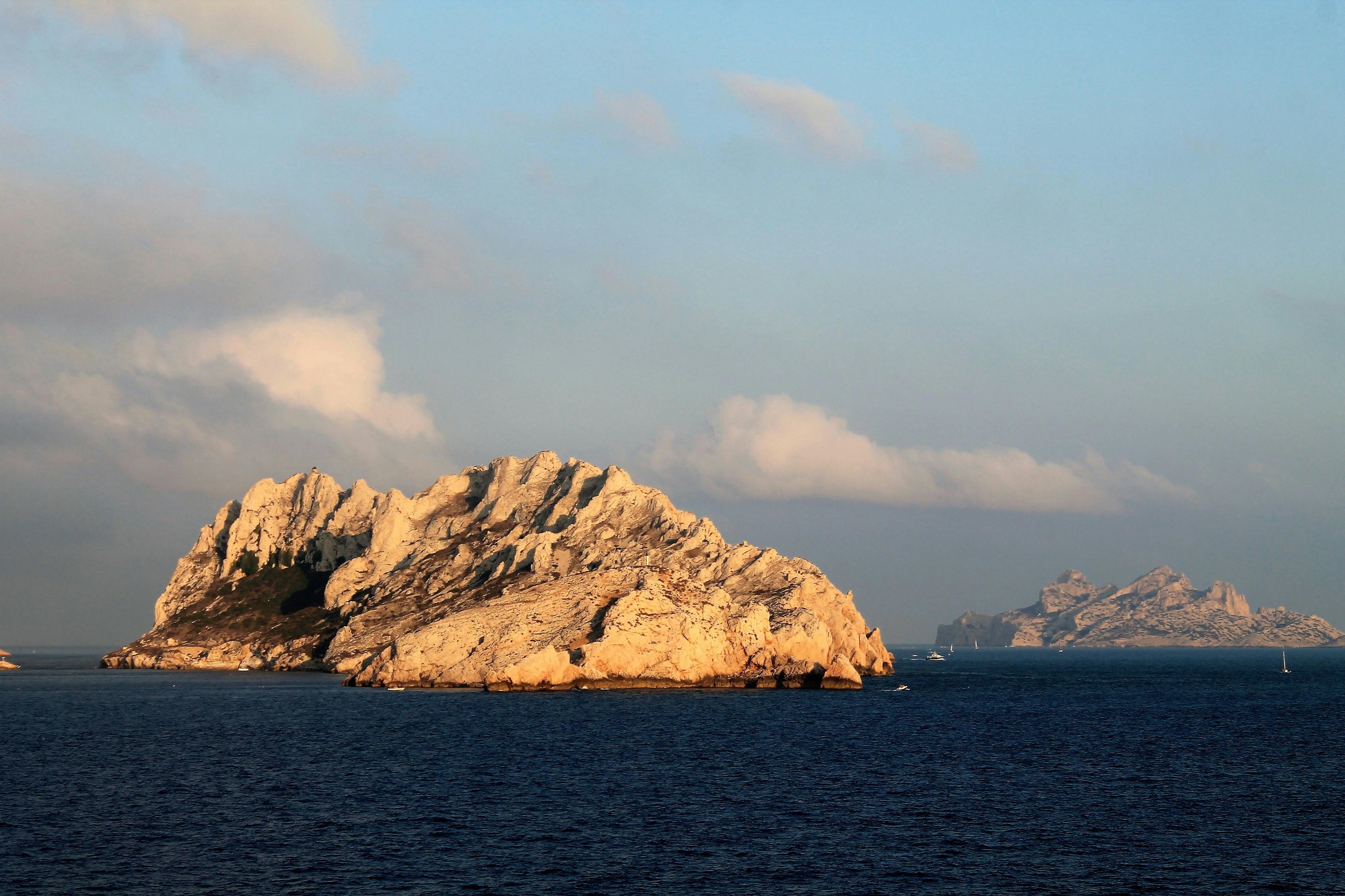 Person Standing behind Rocks on Wasteland · Free Stock Photo