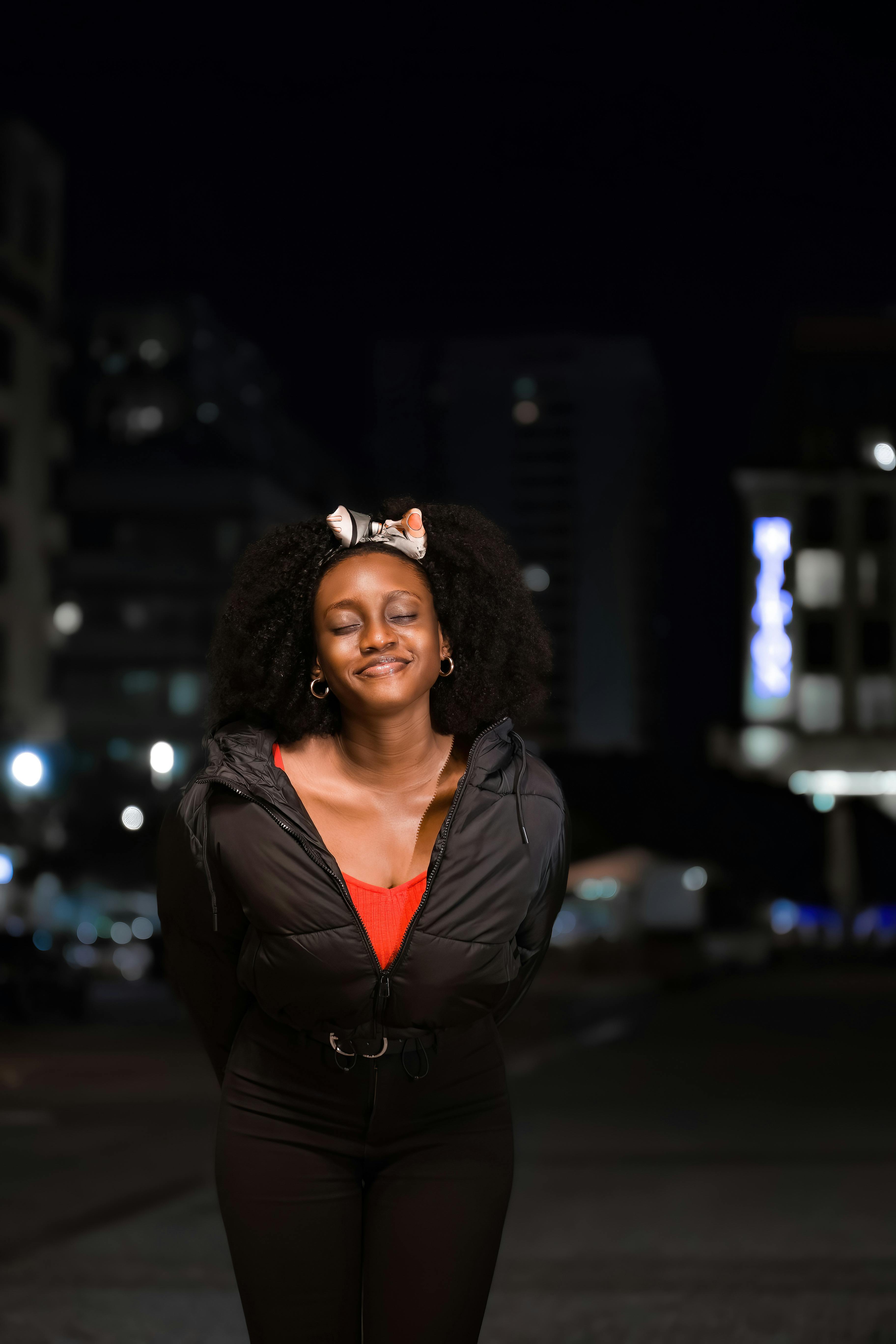 Woman with Eyes Closed in Black Jacket at Night · Free Stock Photo