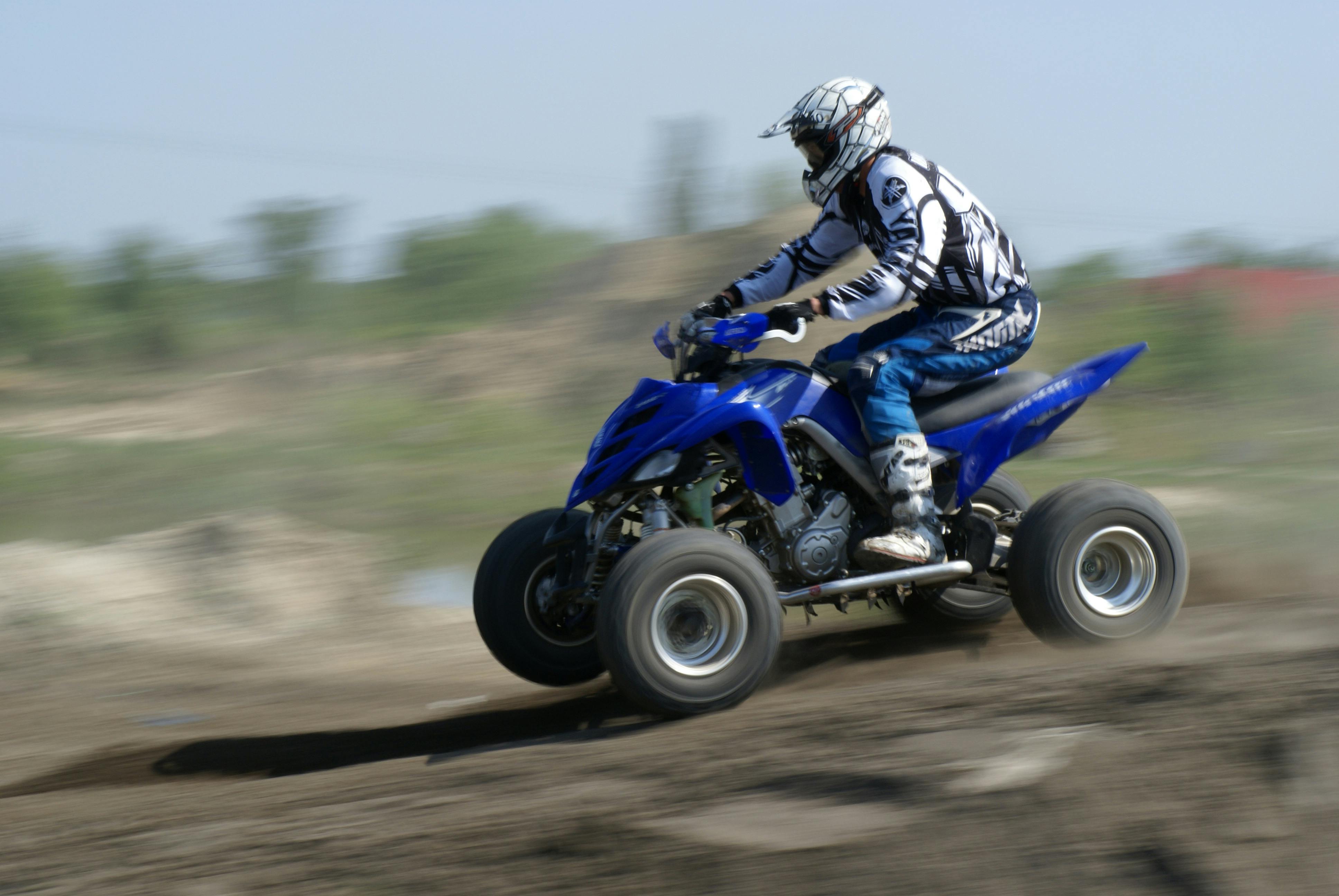 A person riding a blue and white quad bike · Free Stock Photo