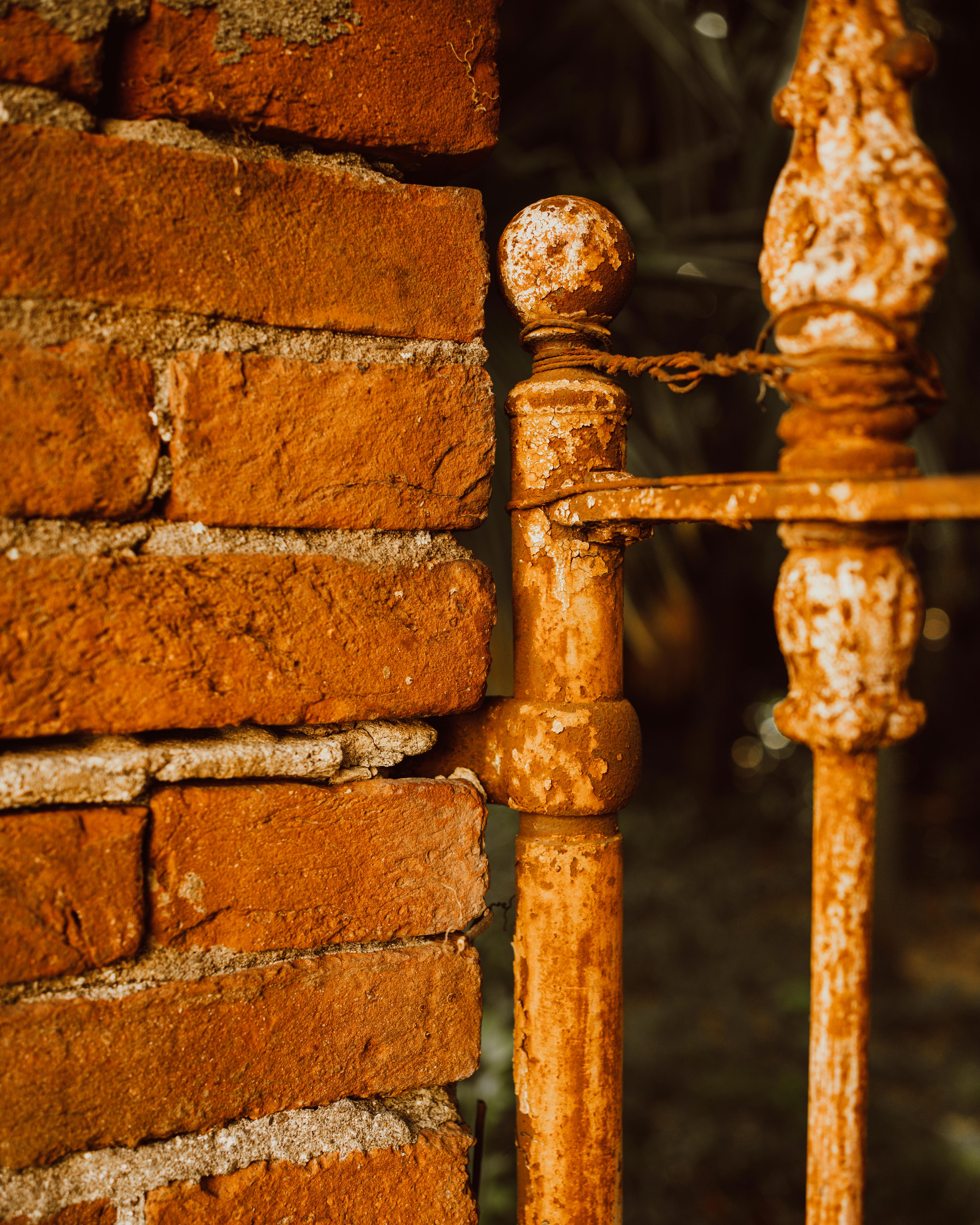 Close-up of a Brick Wall and Rusty Metal Poles · Free Stock Photo