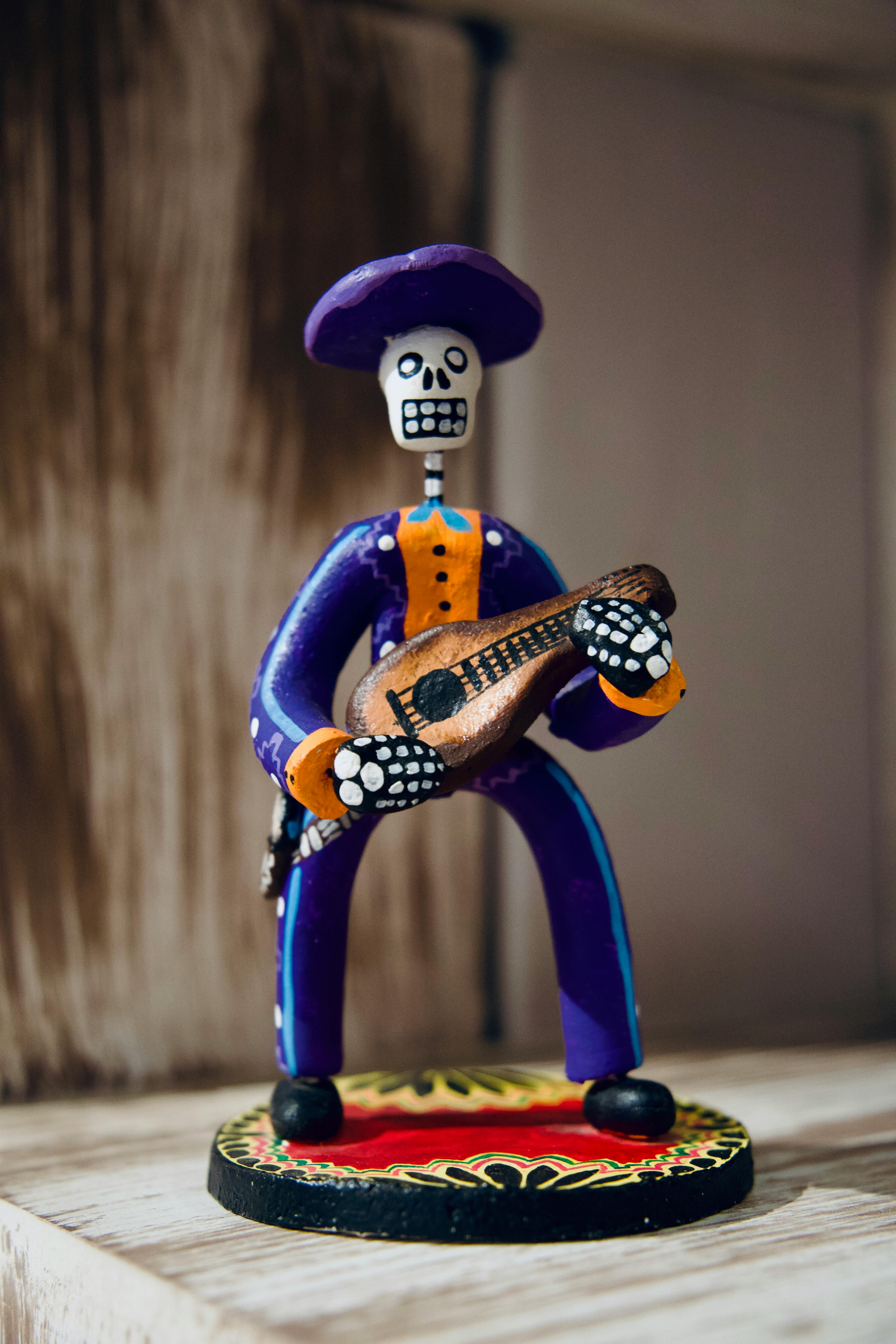 A figurine of a man playing a guitar · Free Stock Photo