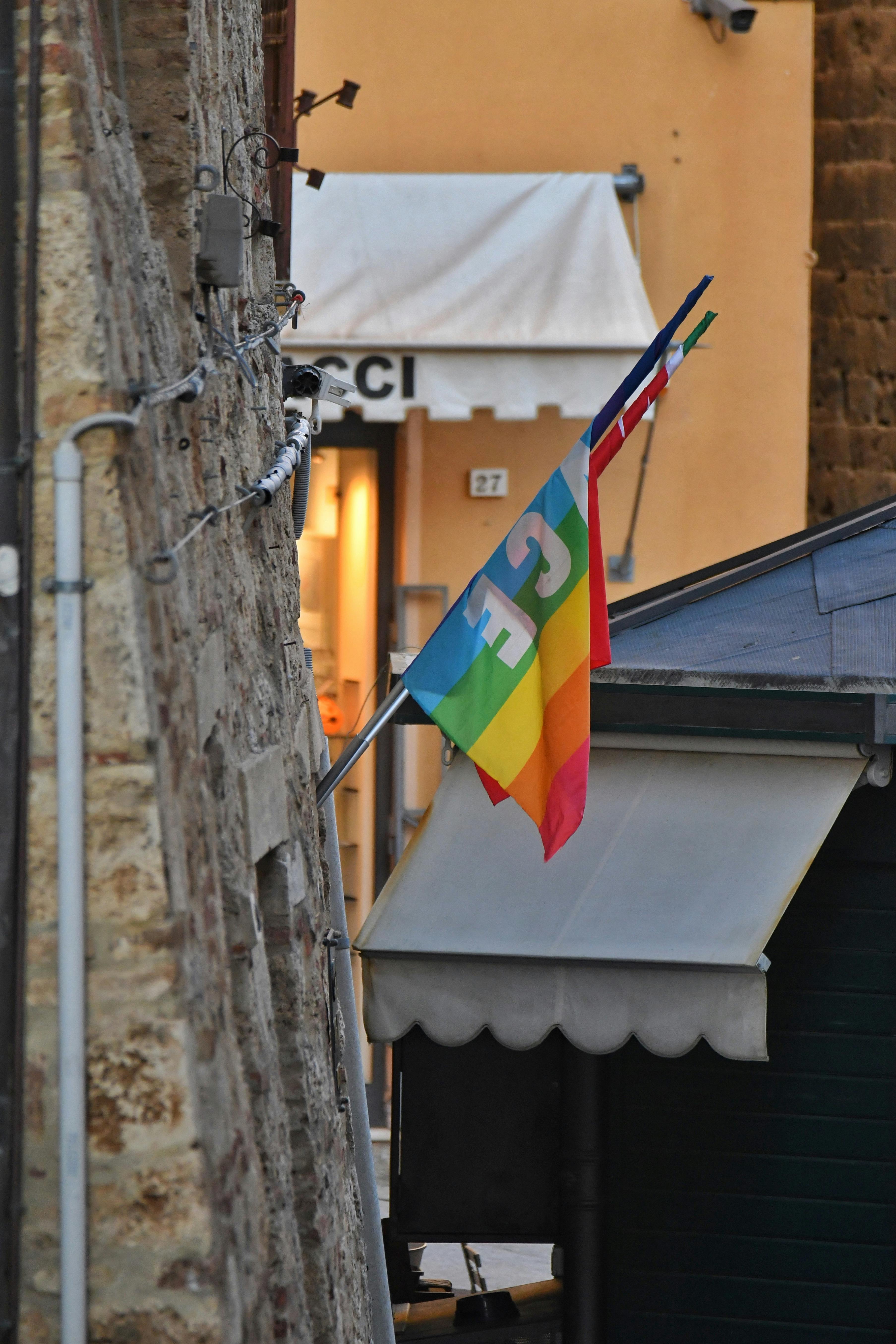 Rainbow Flag Hanging from Building Wall · Free Stock Photo