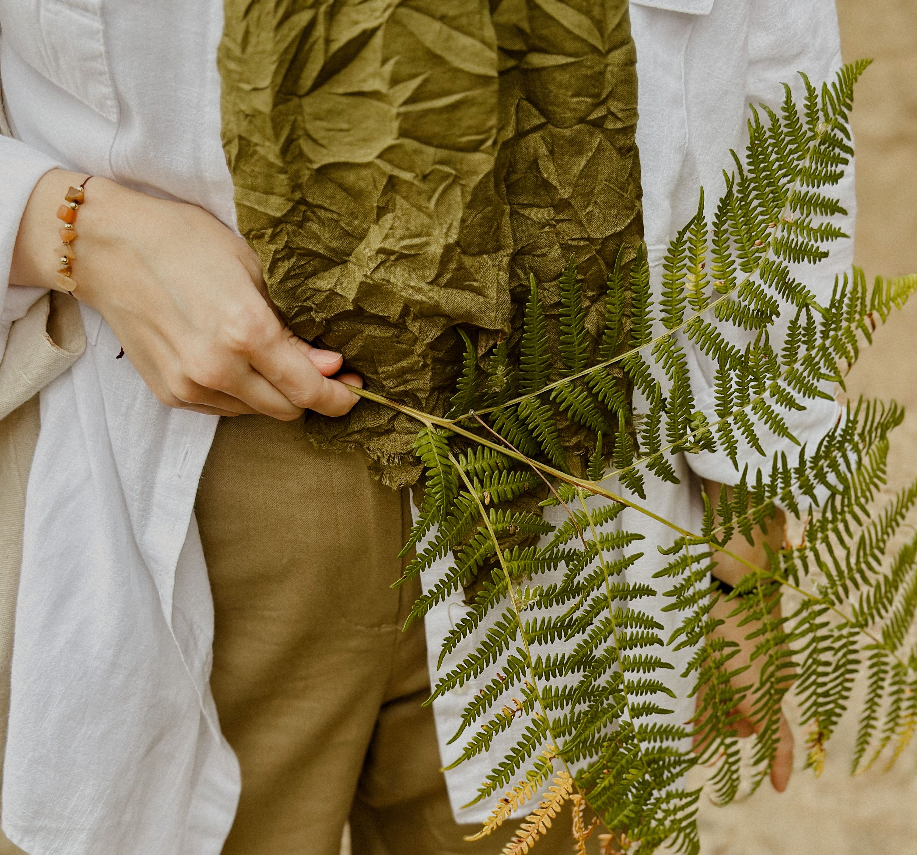 A woman holding a fern leaf in her hand · Free Stock Photo