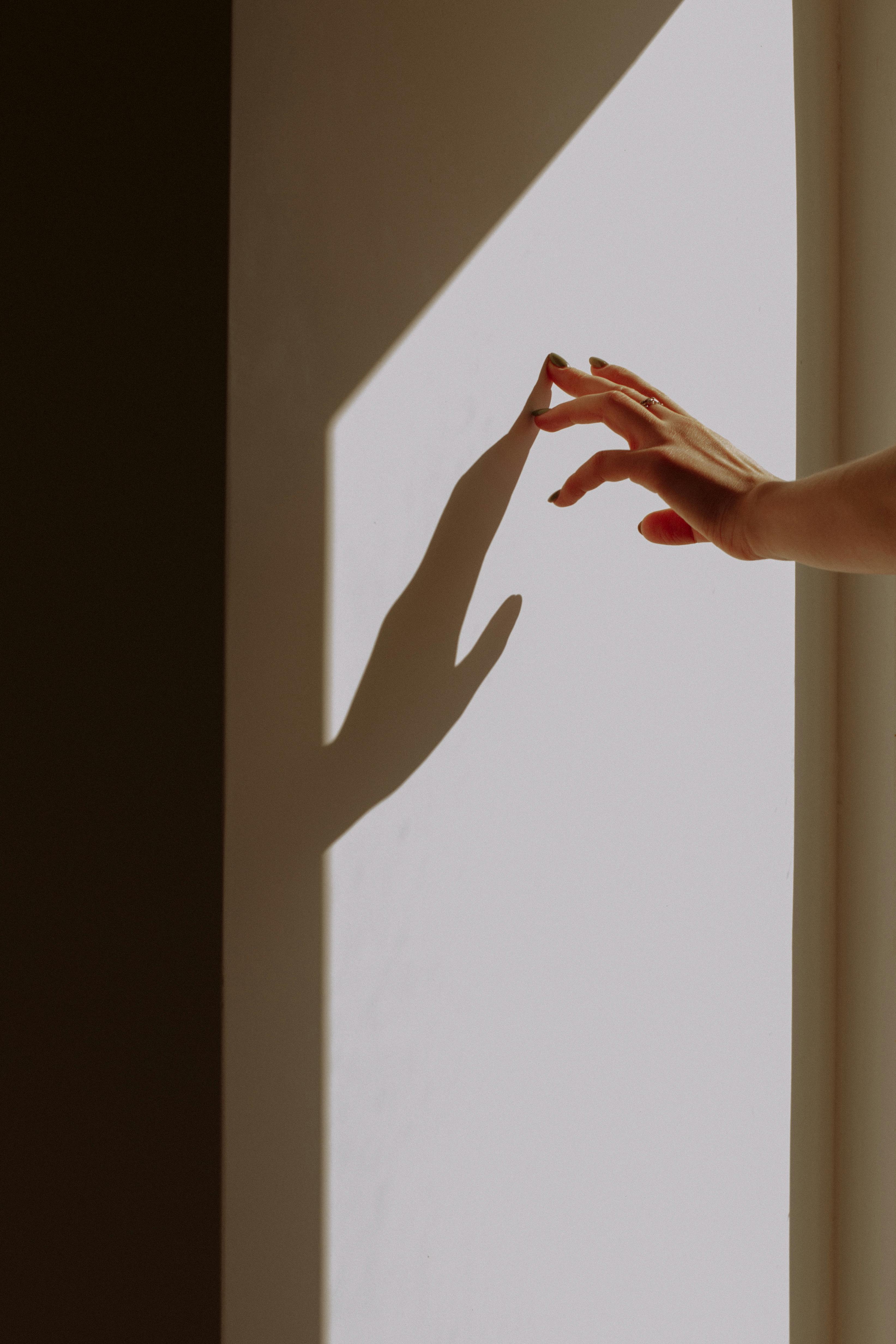 Hand Casting Shadow on Wall · Free Stock Photo